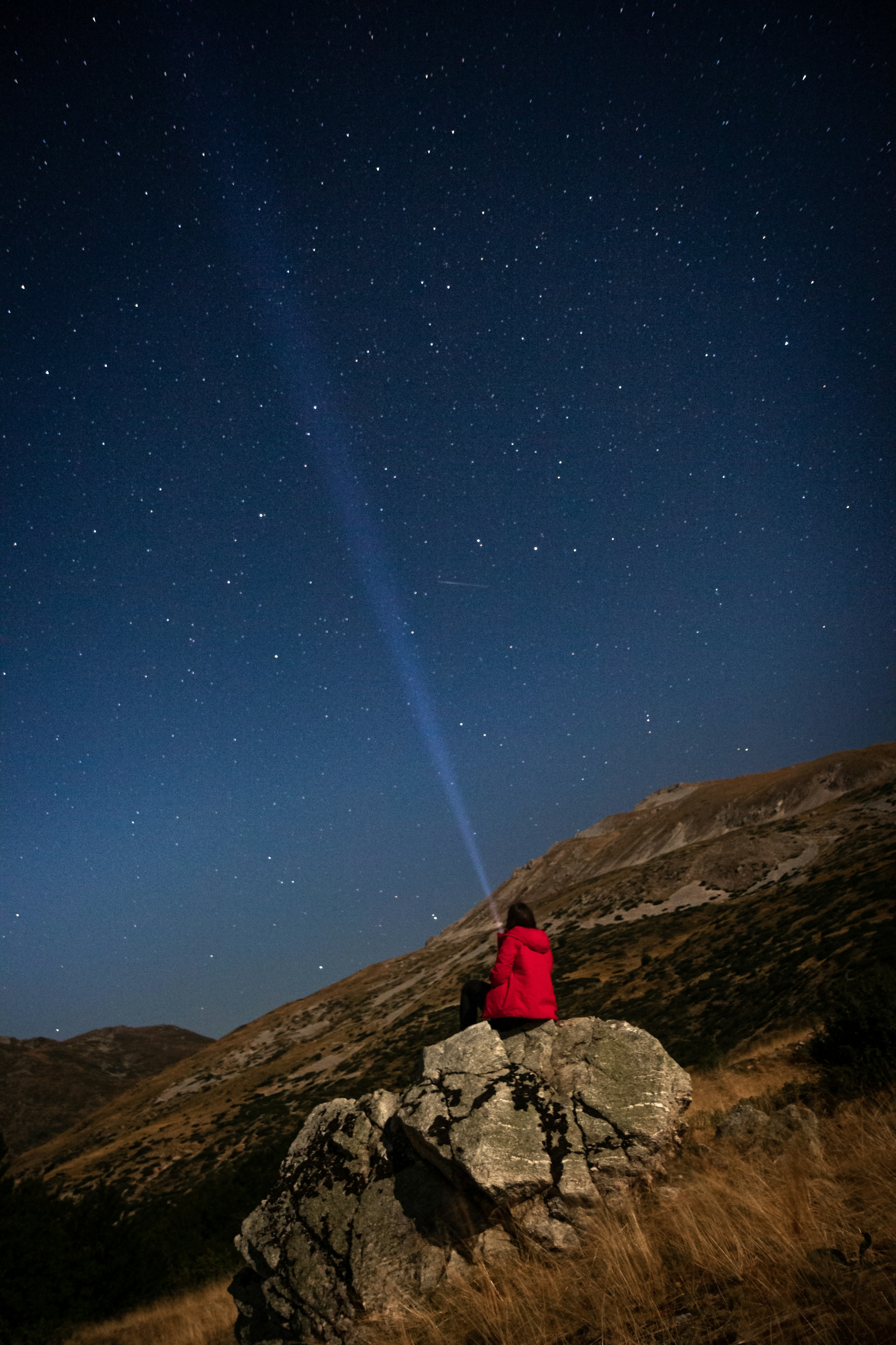 Beacon in the Dark: A Shattered Night Sky and a Red-Hued Sentinel