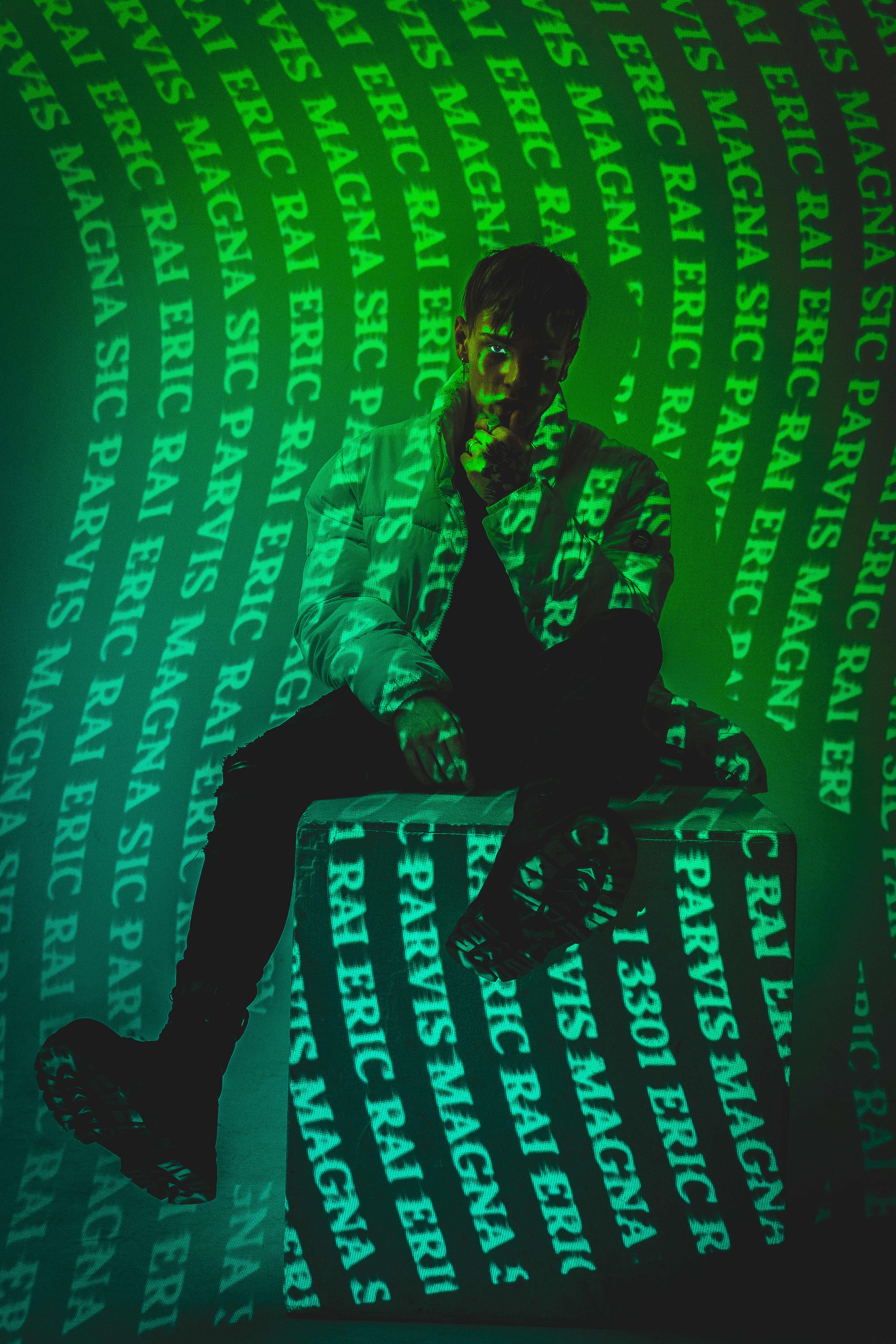 a man sitting on a bench in front of a green background