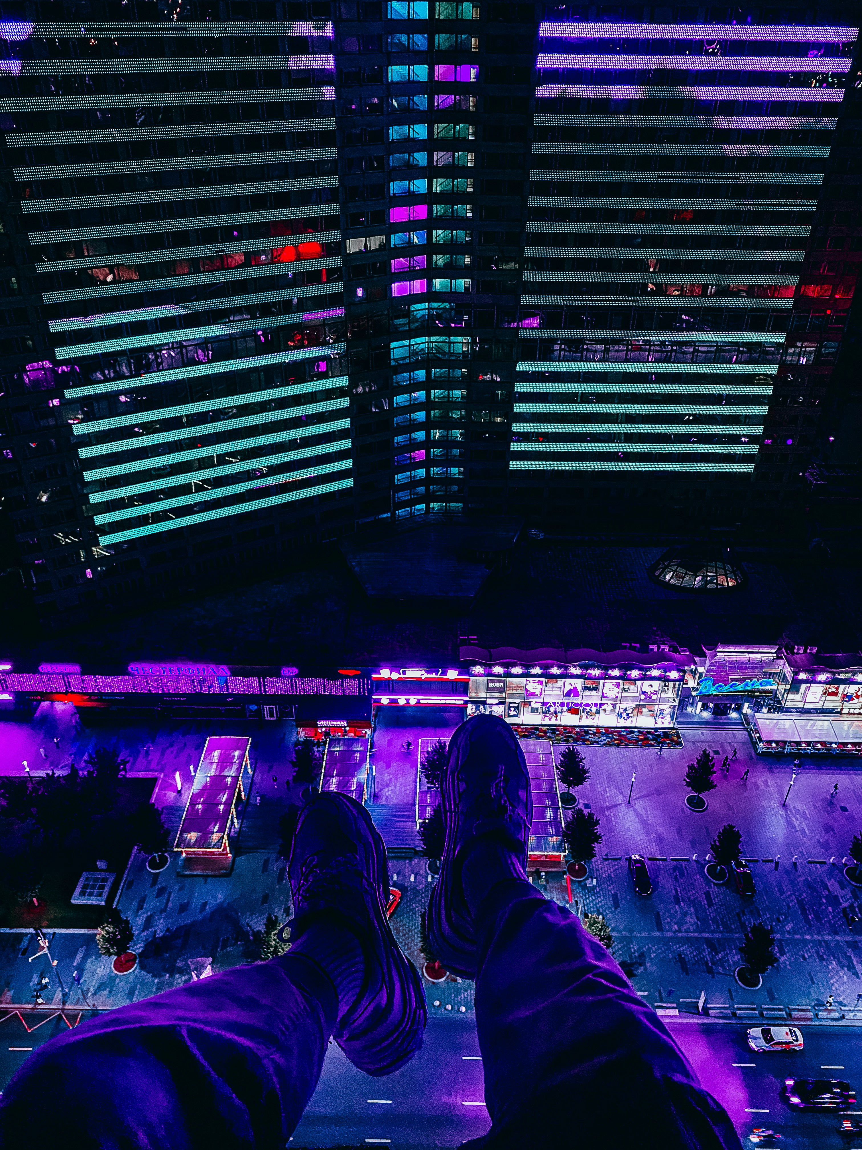 Neon Overlook: Feet Dangling Above a Violet City