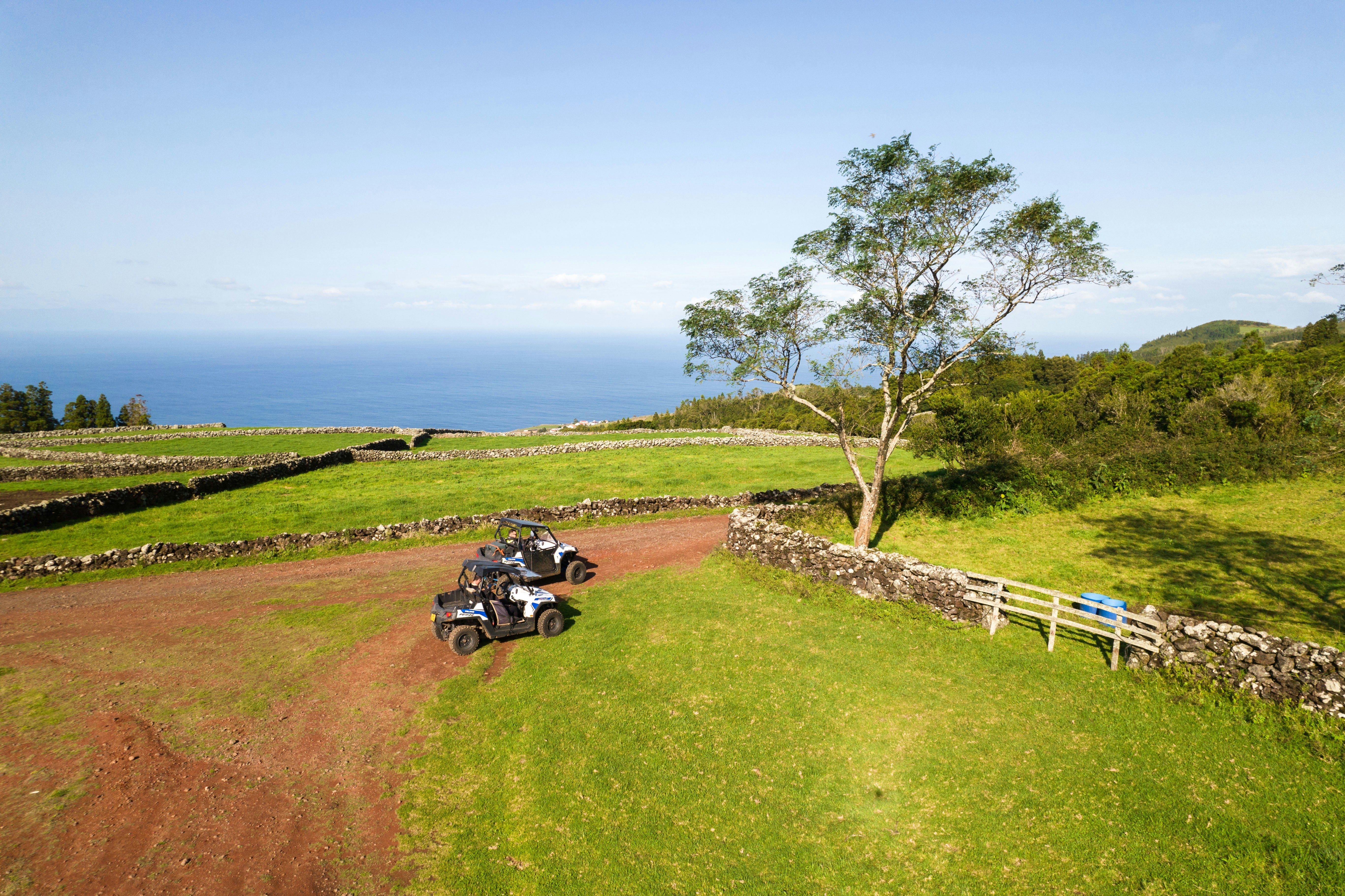 riding a buggy in azores | a person riding a four wheeler on a dirt road