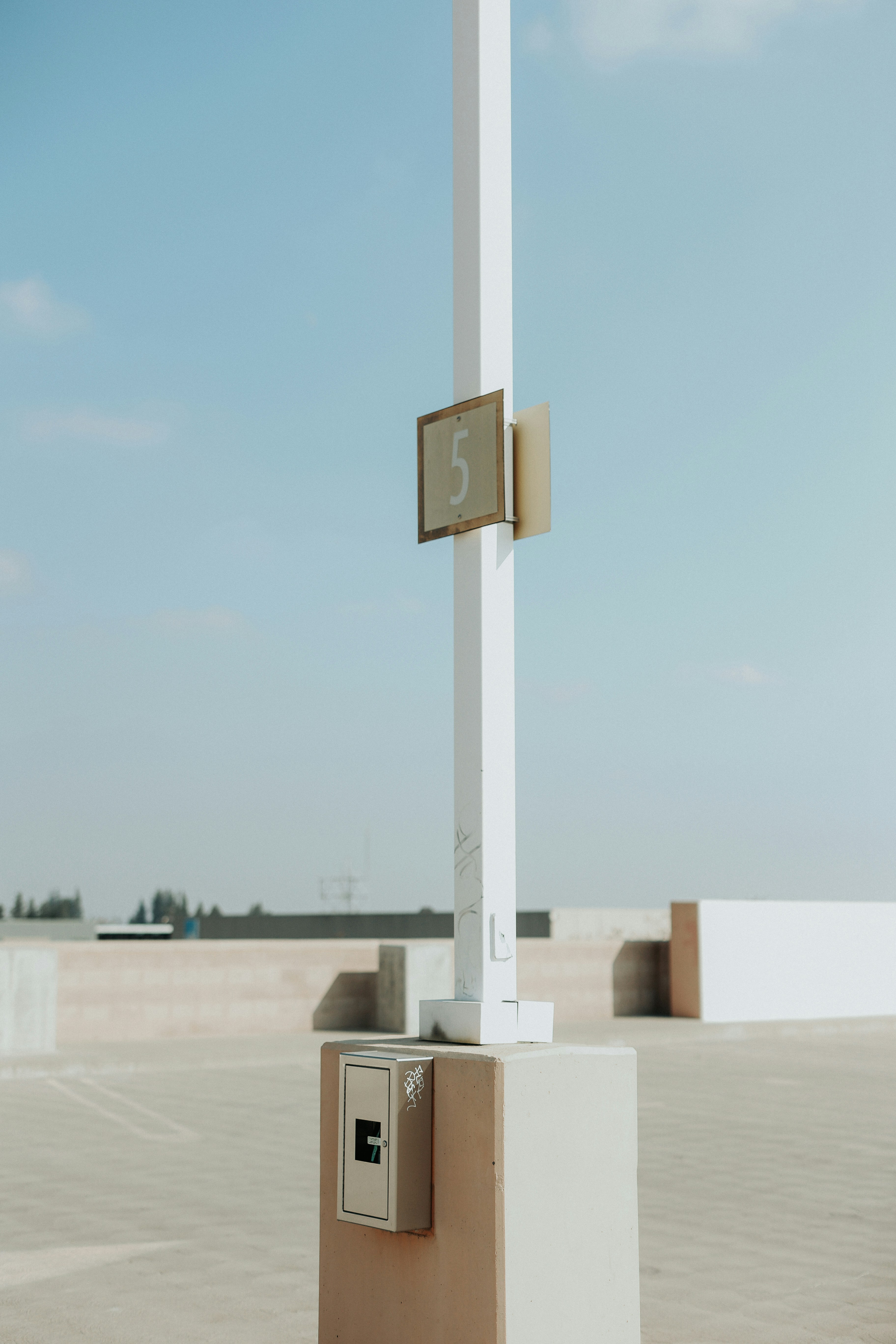 Five on the Rooftop: A Minimalist Pole Against a Clear Sky