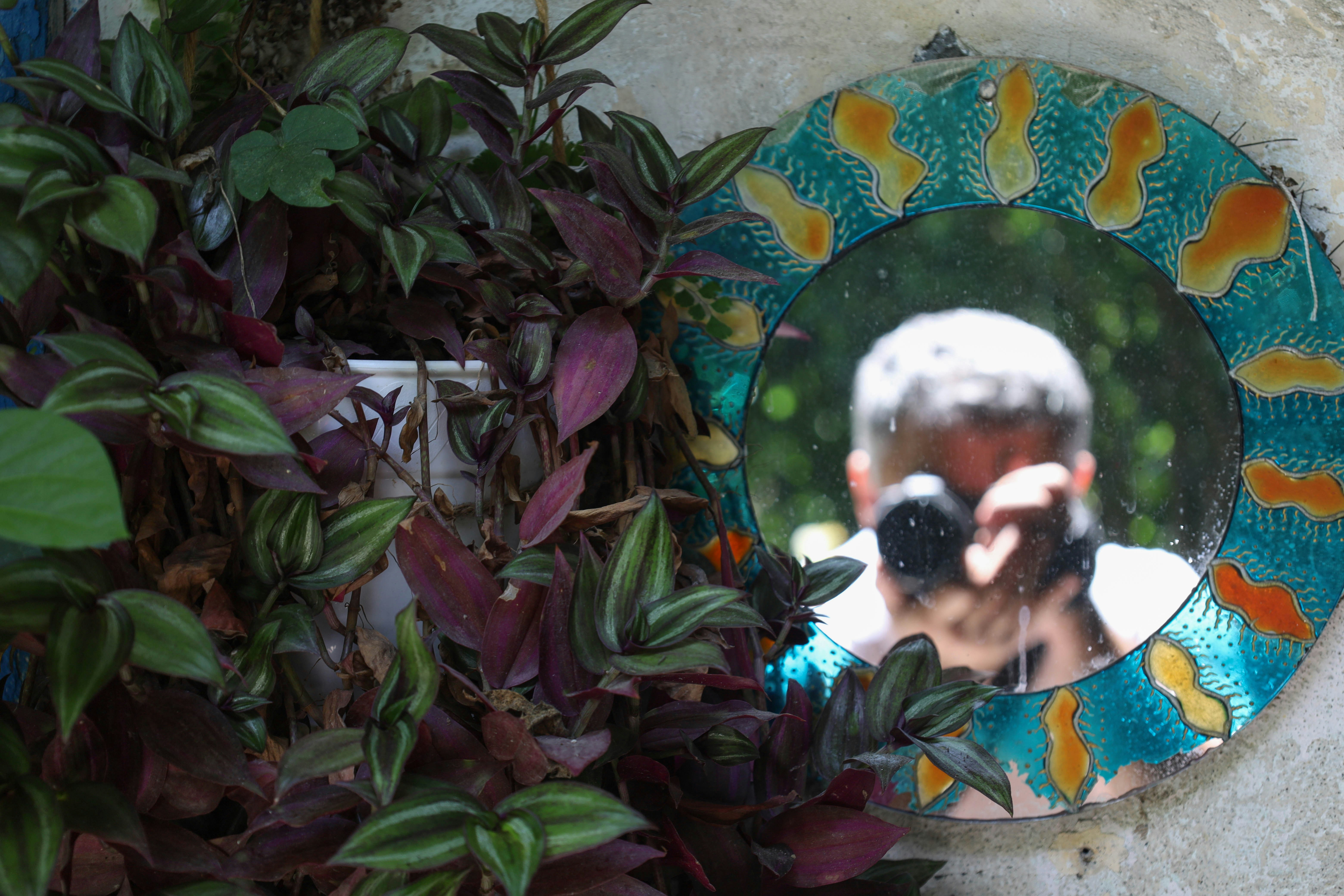 Circle of Reflection: A Photographer Framed by Vines in a Colorful Garden Mirror