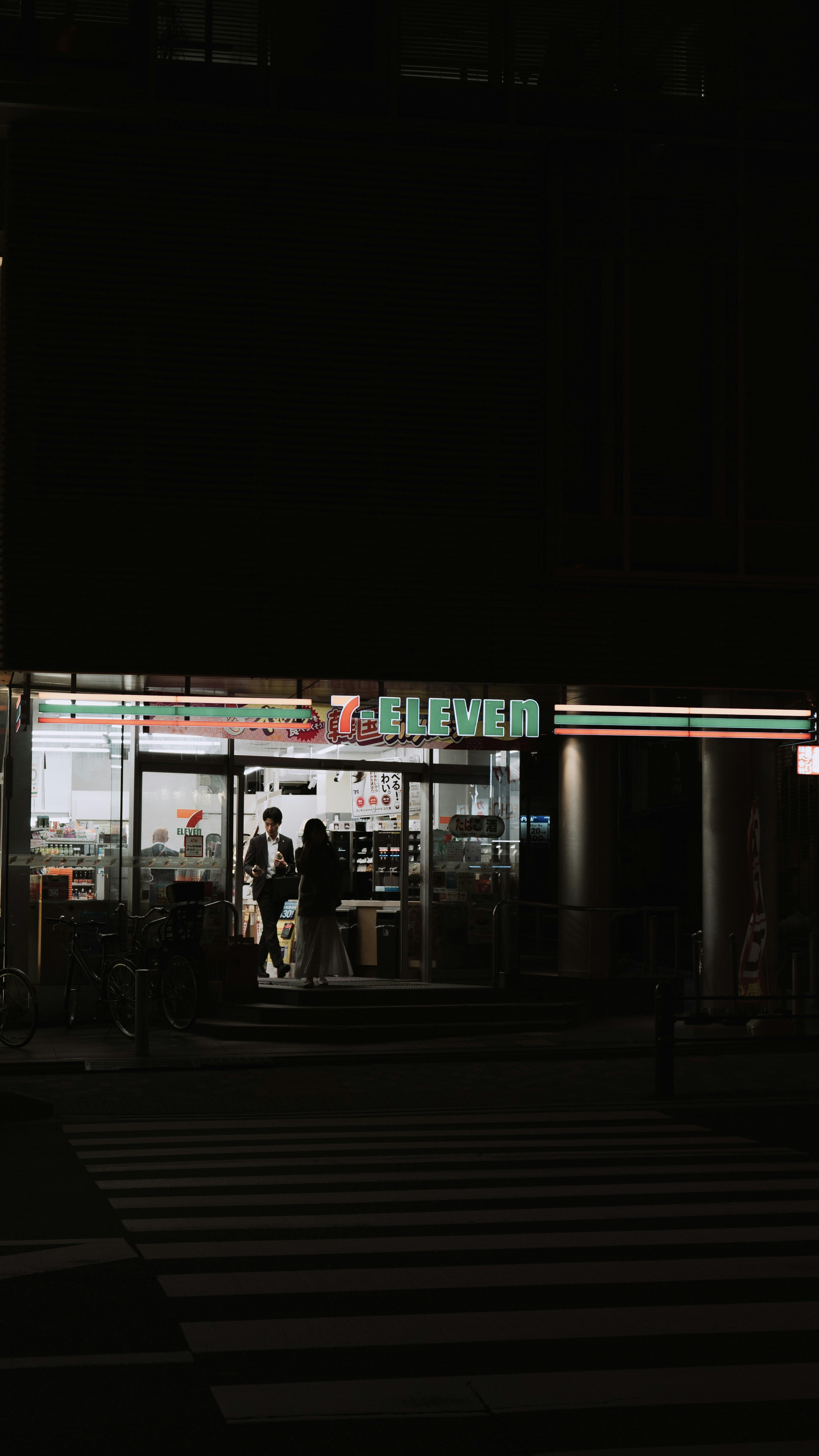 A group of people standing outside of a store at night photo – Free ...