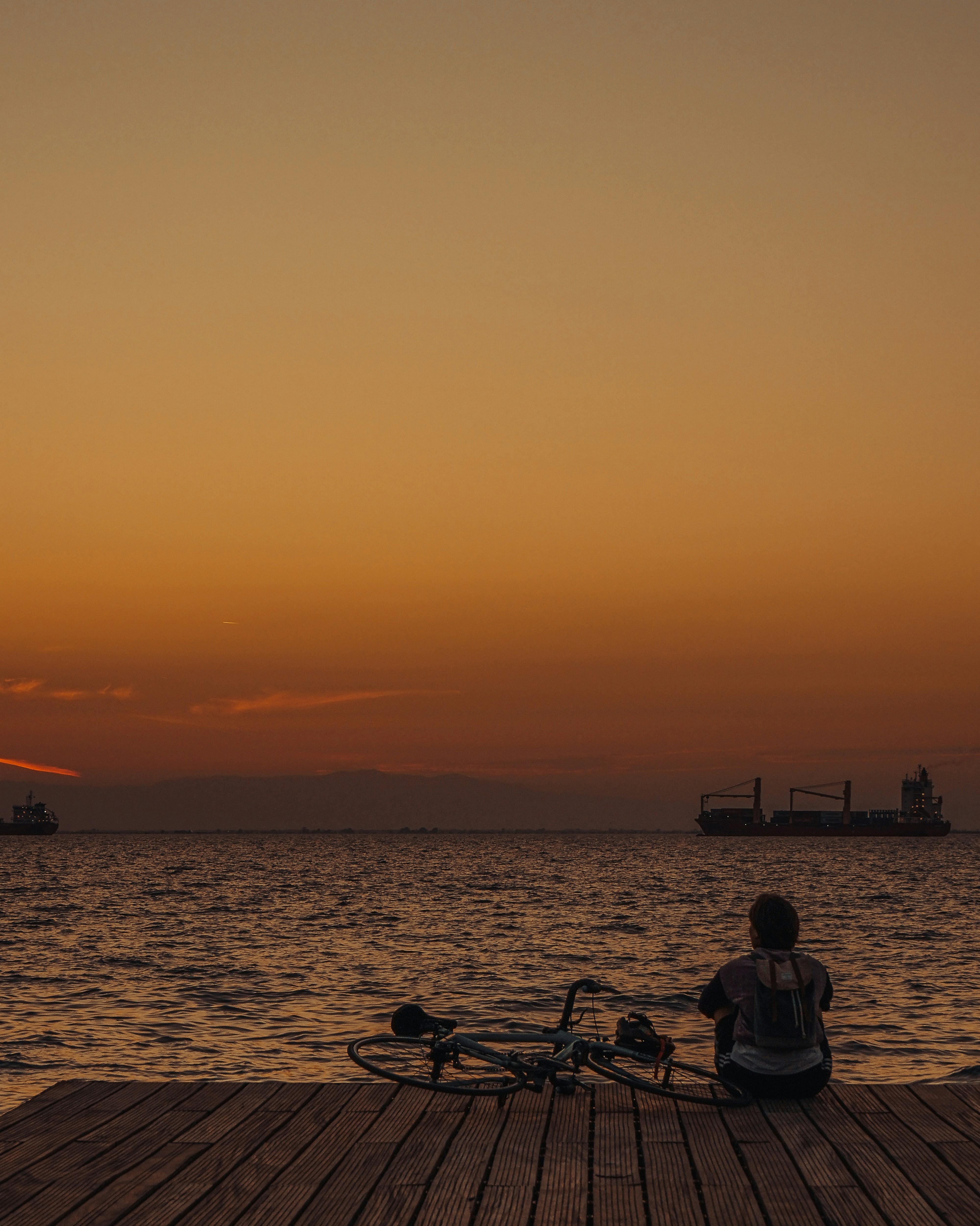 Twilight on the Pier: A Solitary Moment with a Bicycle by the Quiet Horizon