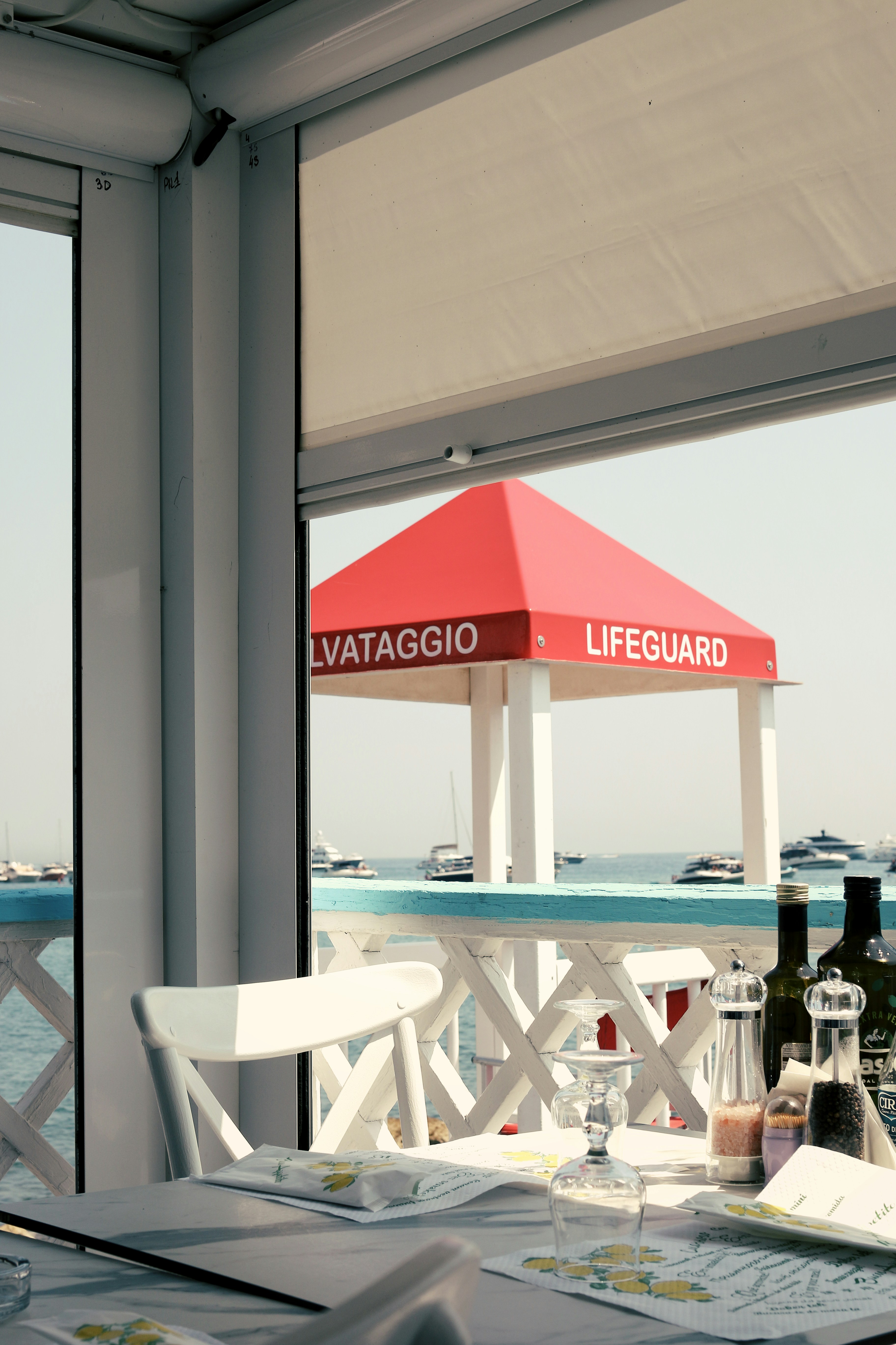Crimson Lifeguard Canopy Framing a Quiet Seaside Table