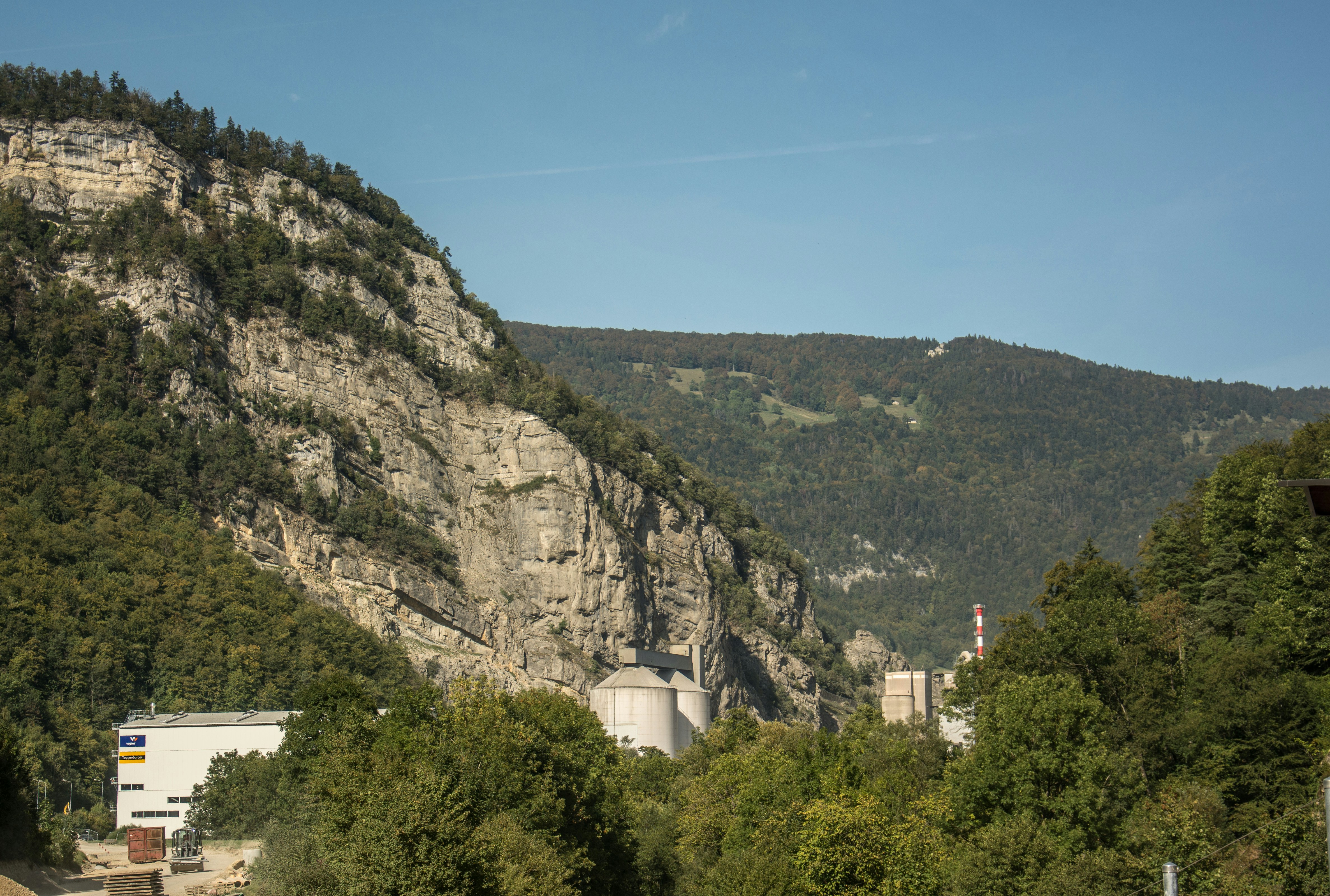 A view of a mountain with a large silo in the foreground photo – Free ...