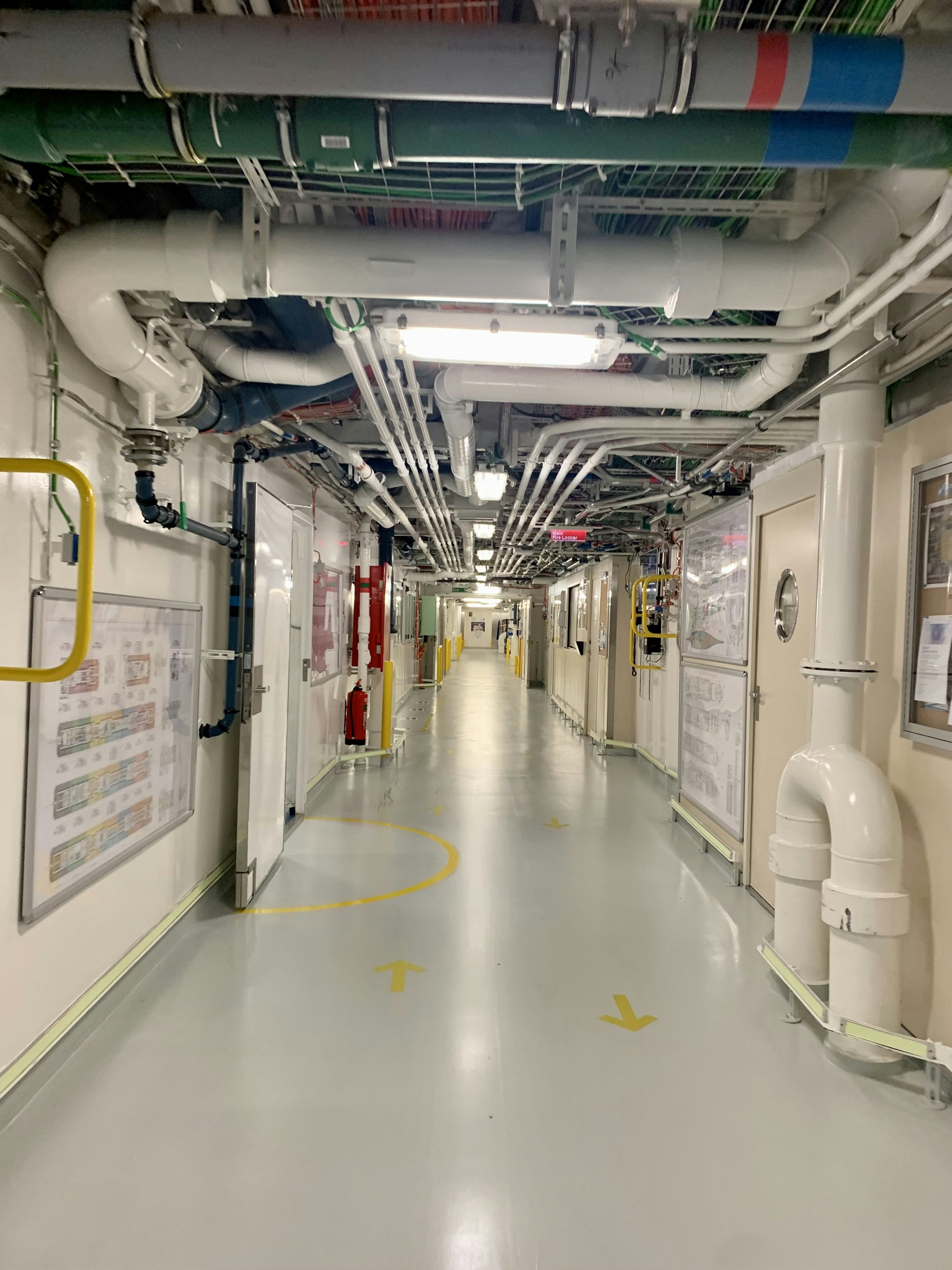 A long hallway with pipes and pipes on the ceiling photo – Free Crew ...