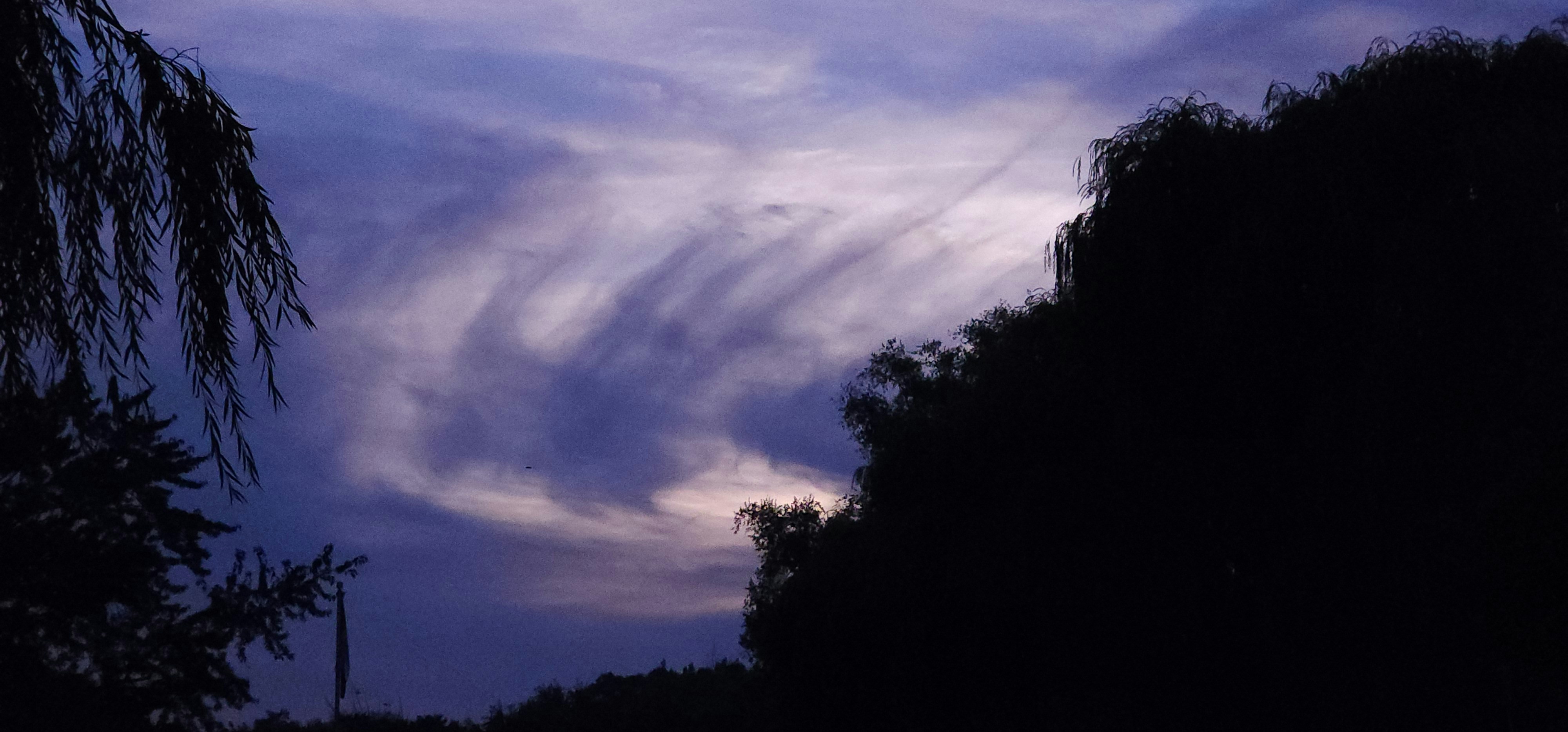 Twilight Threads: Wispy Clouds Sweep a Silhouetted Skyline