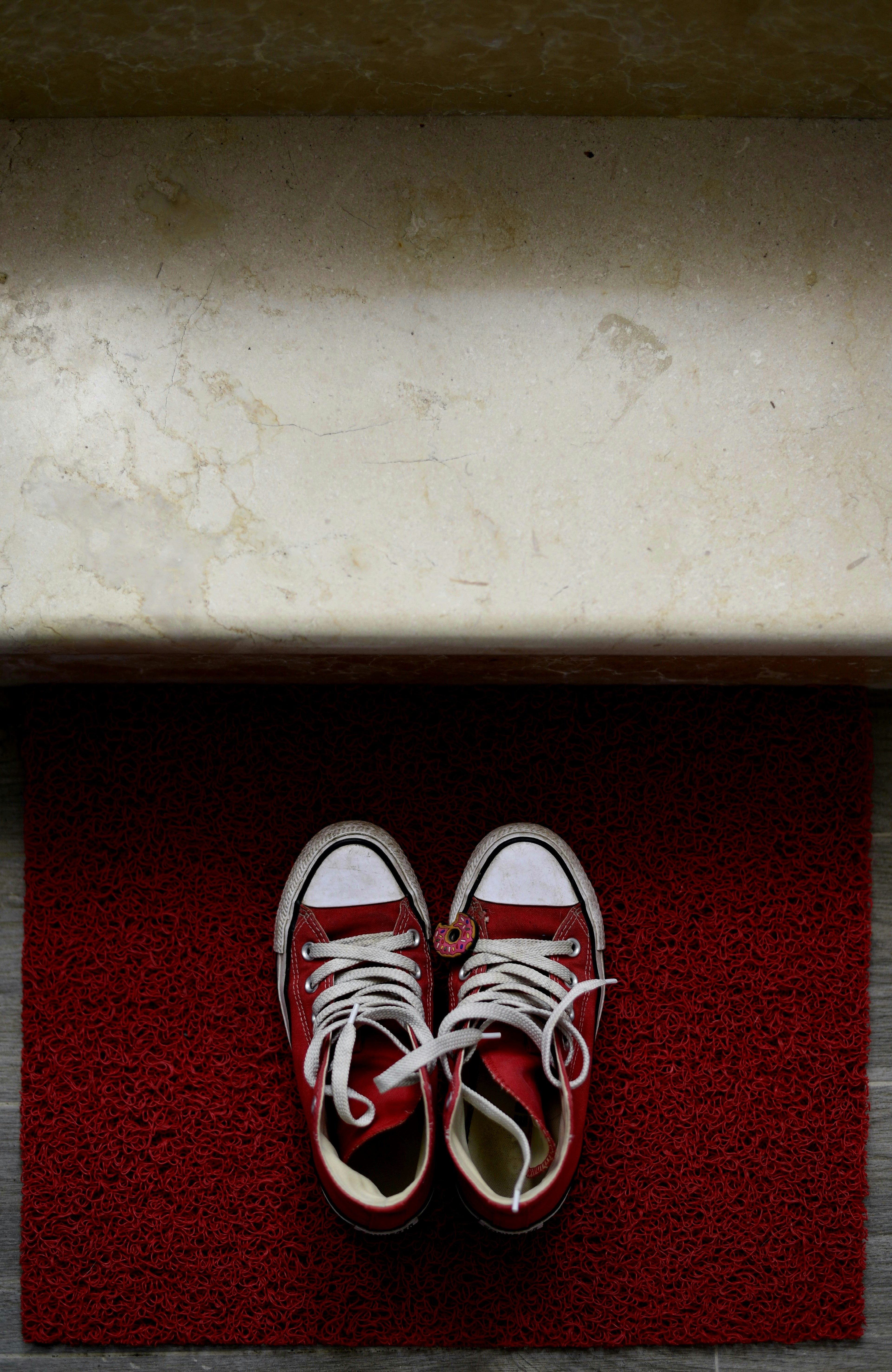 a pair of red sneakers sitting on top of a red rug