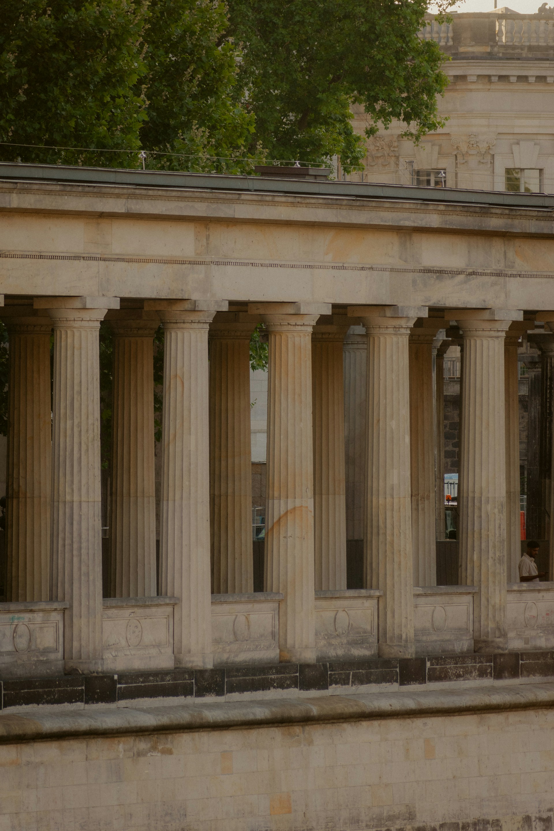 A row of stone pillars in front of a building photo – Free City Image ...