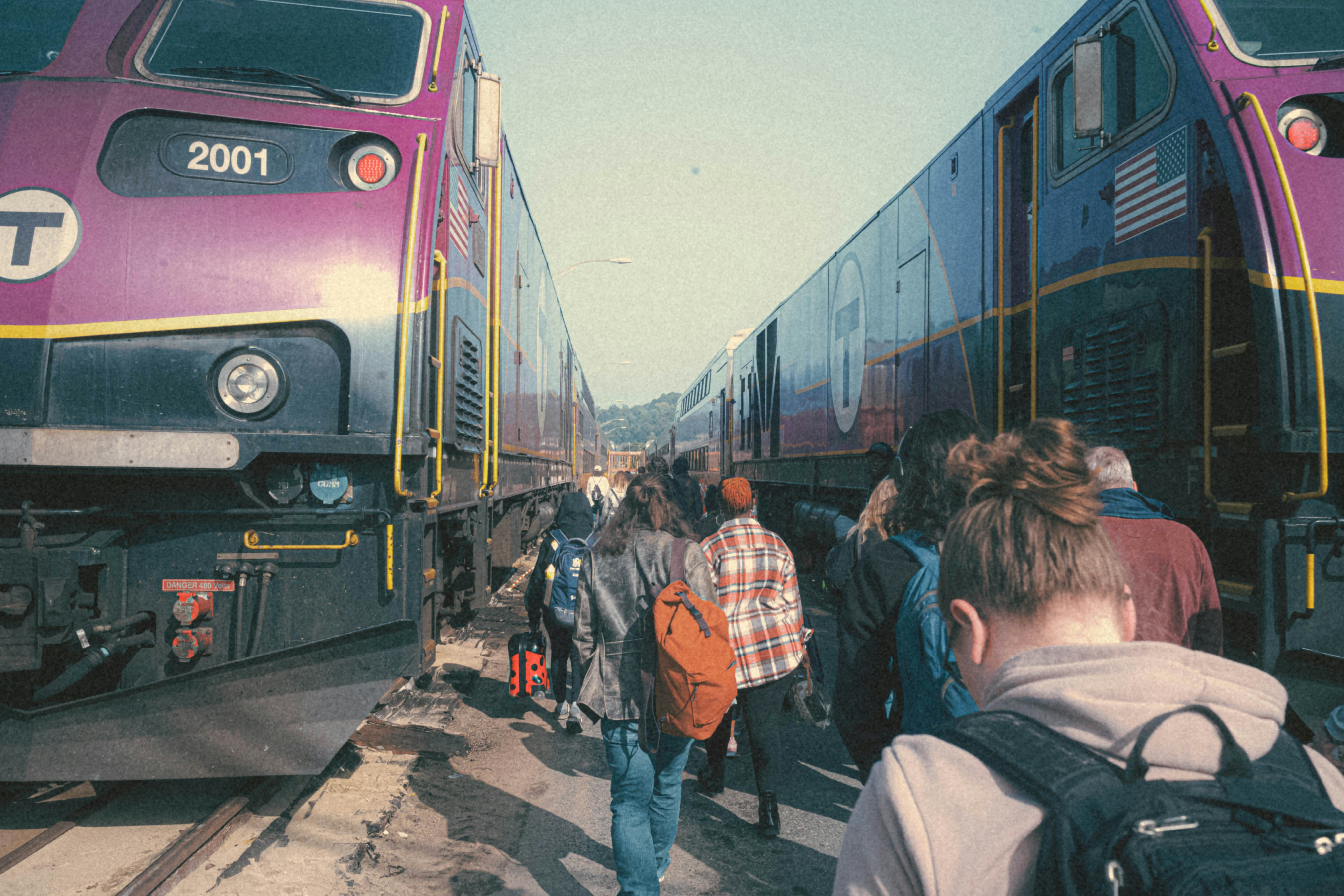 A group of people standing next to two trains photo – Free Woman Image ...