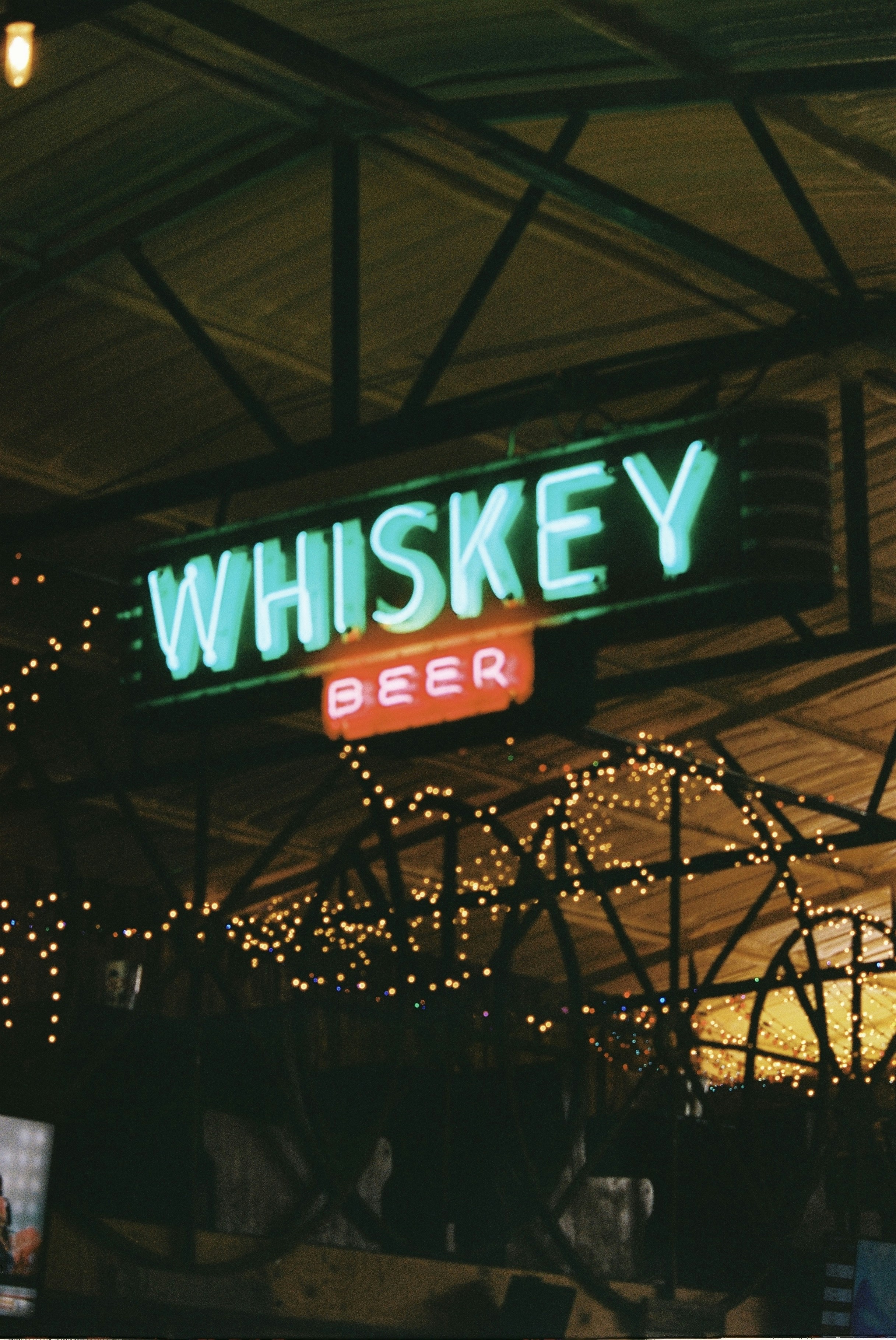 A sign that reads whiskey beer hanging from the ceiling photo – Free ...
