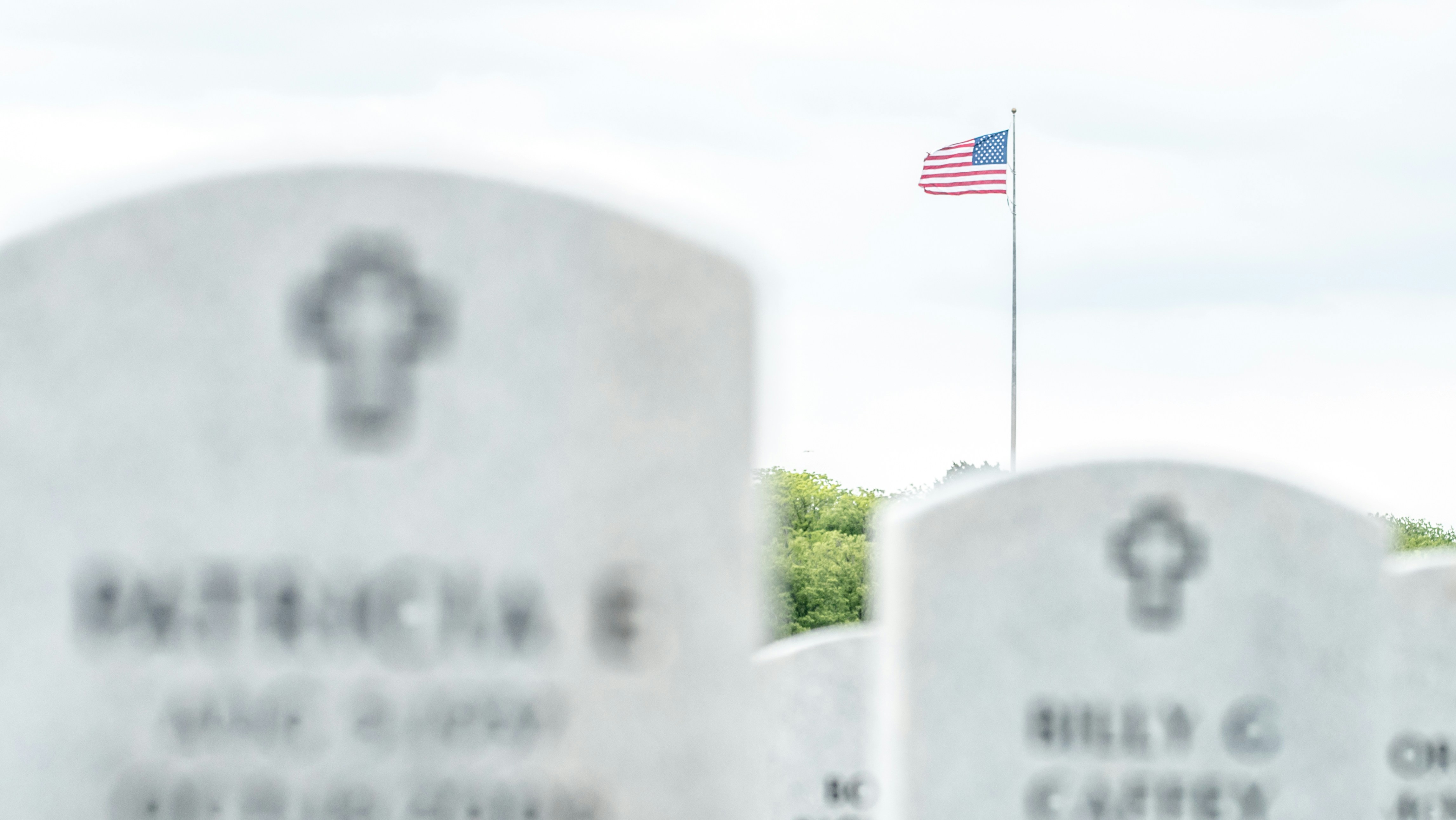 A flag flying over a cemetery with headstones photo – Free Cemetery ...