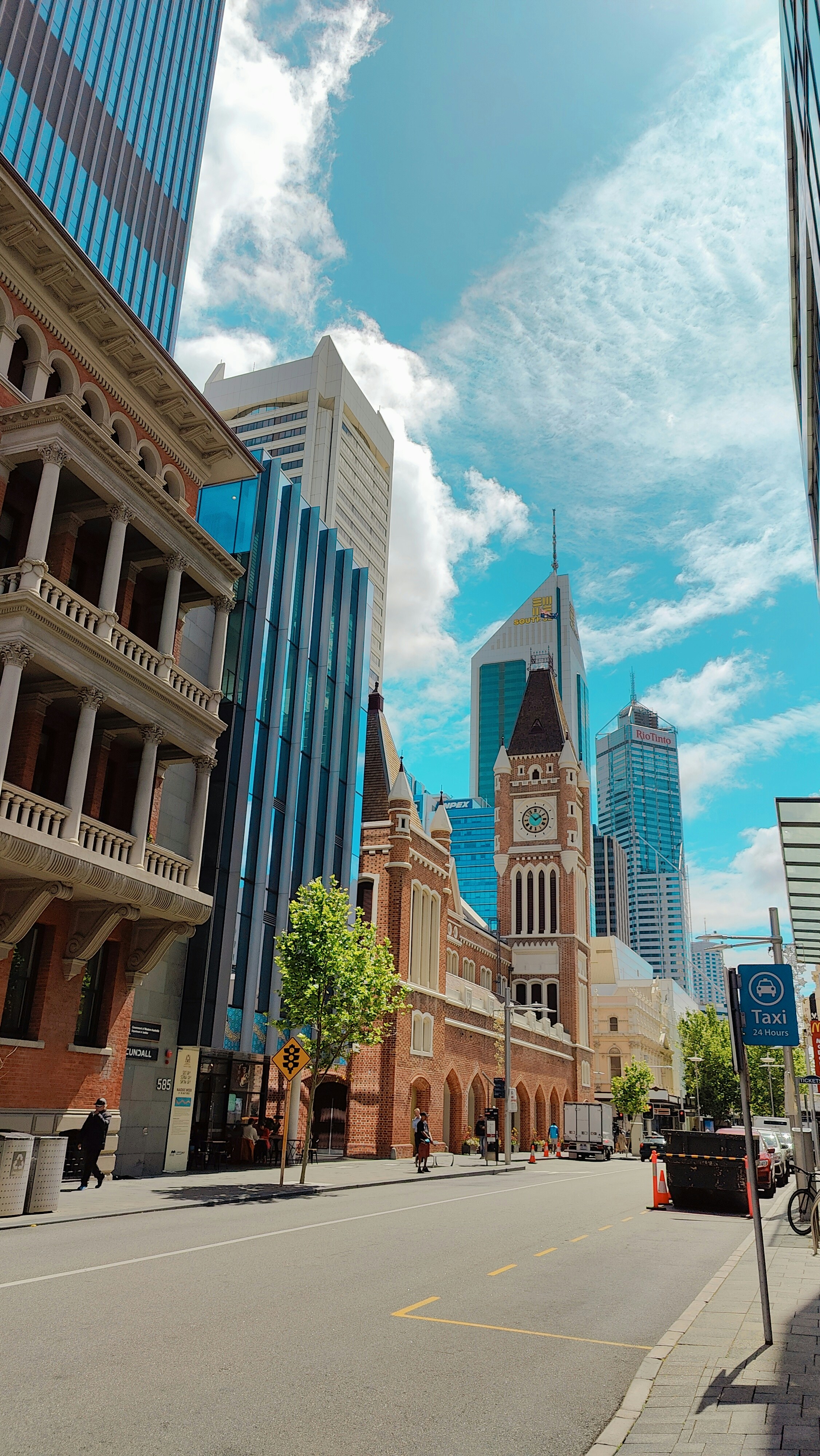 A city street with tall buildings and a clock tower photo – Free Perth ...