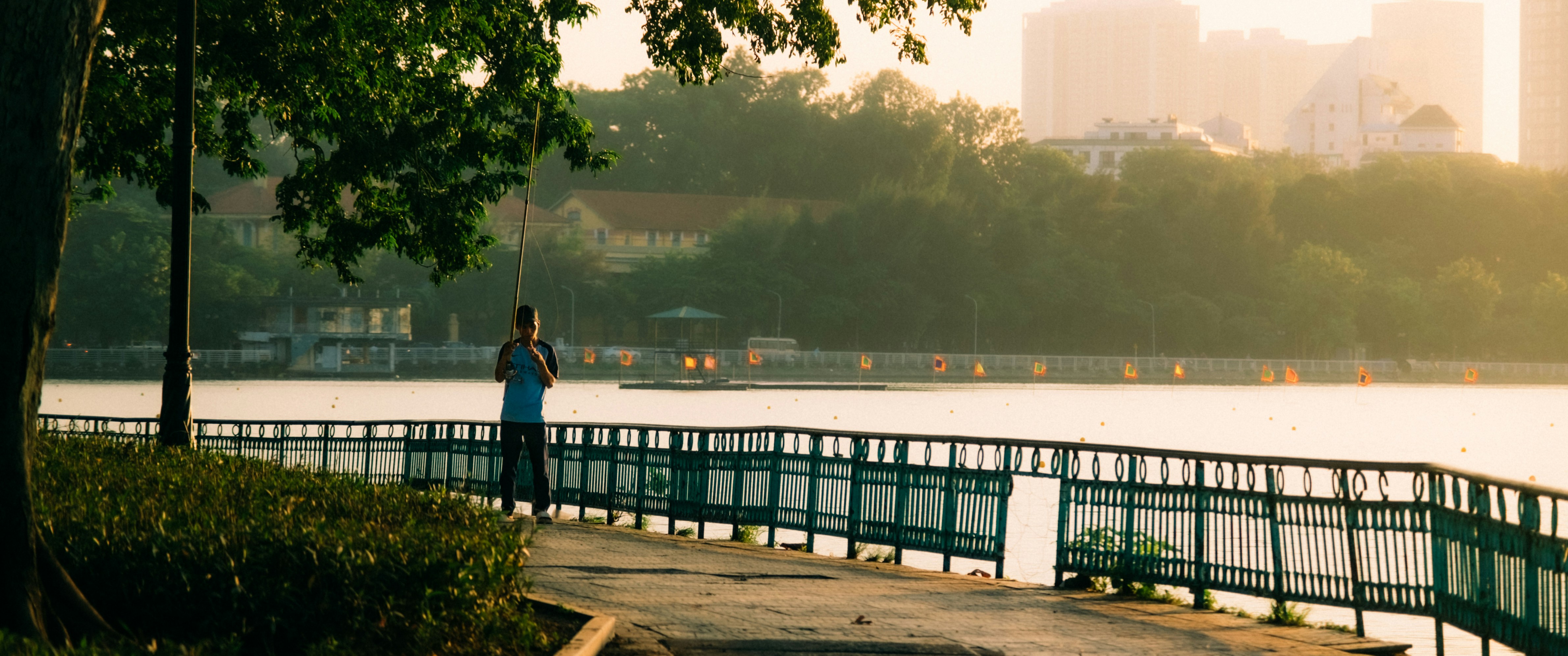 Golden Hour by the Riverside: A Lone Figure at the Rail
