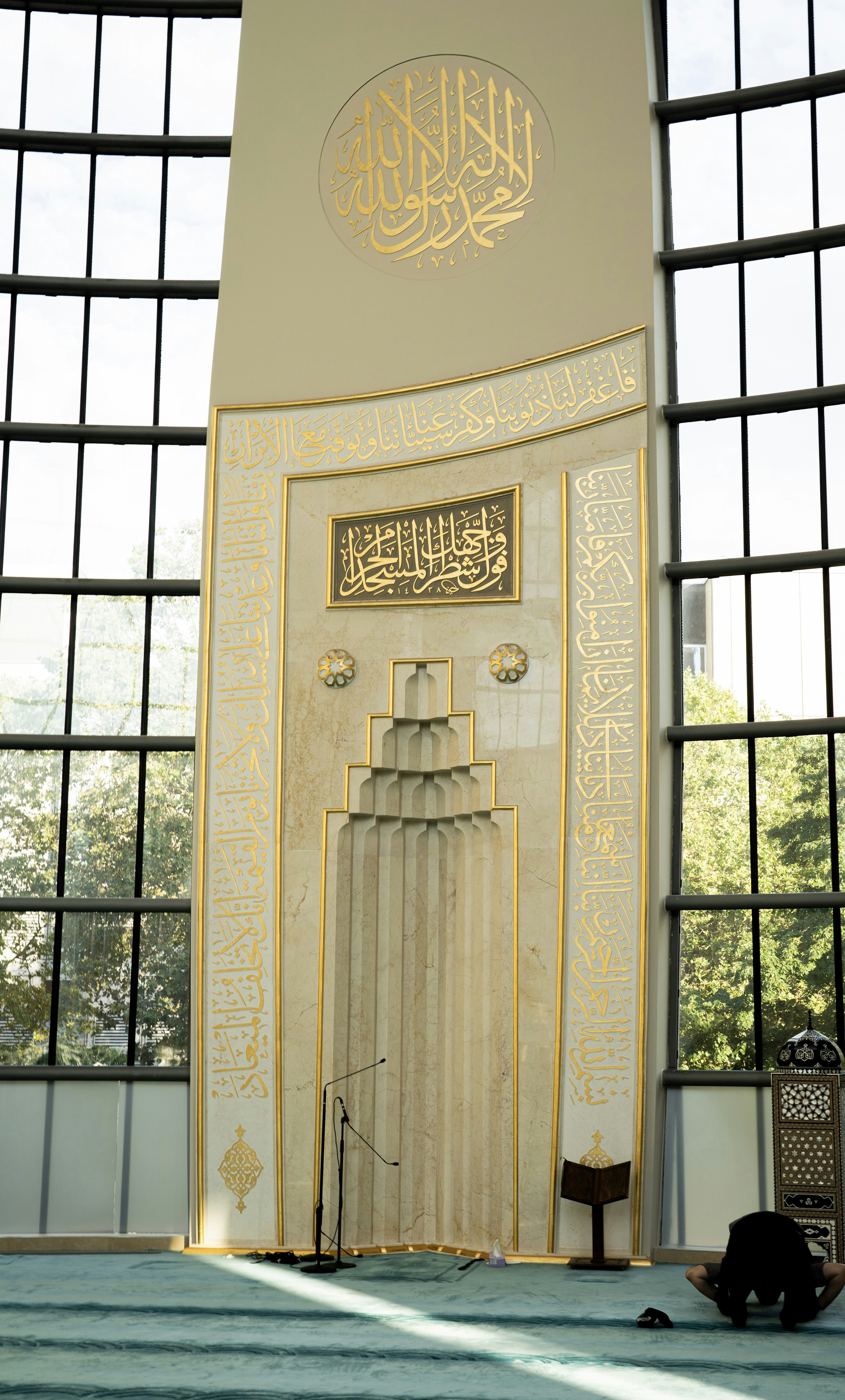 Gilded Mihrab Framed by Glass: Tranquil Light in a Prayer Hall