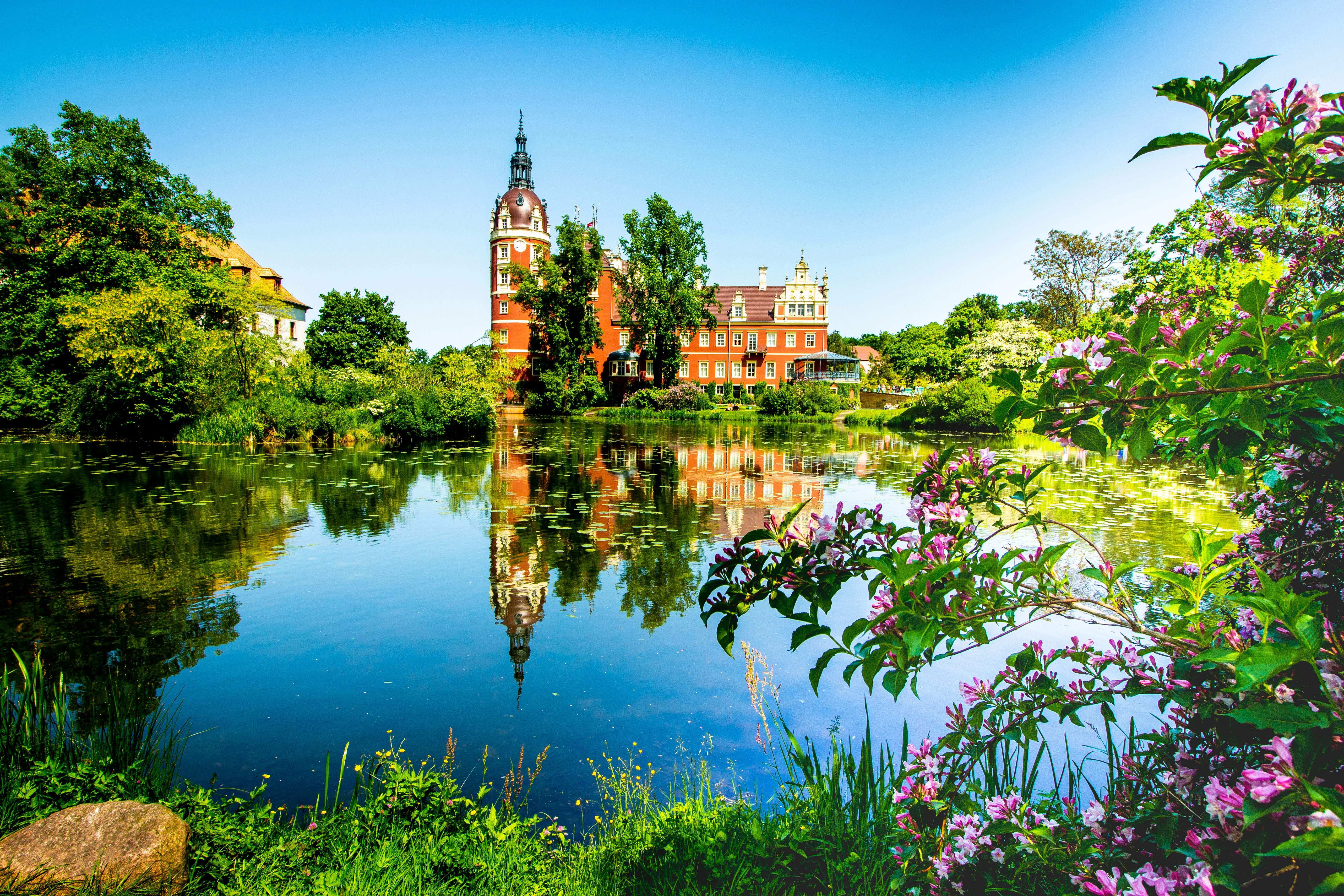 A large building sitting on top of a lush green field photo – Free ...