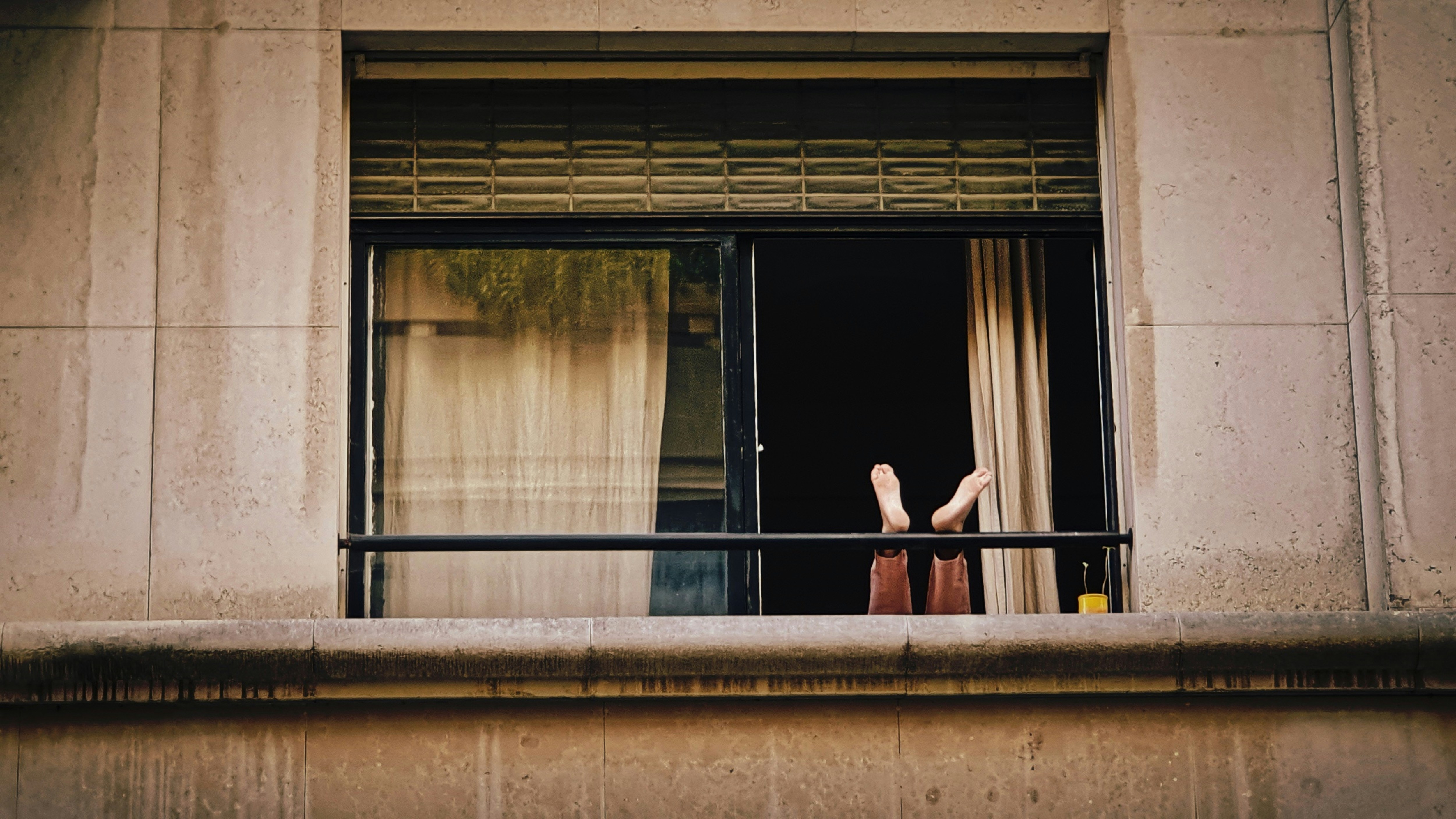 A person standing in front of a window with their arms in the air photo ...