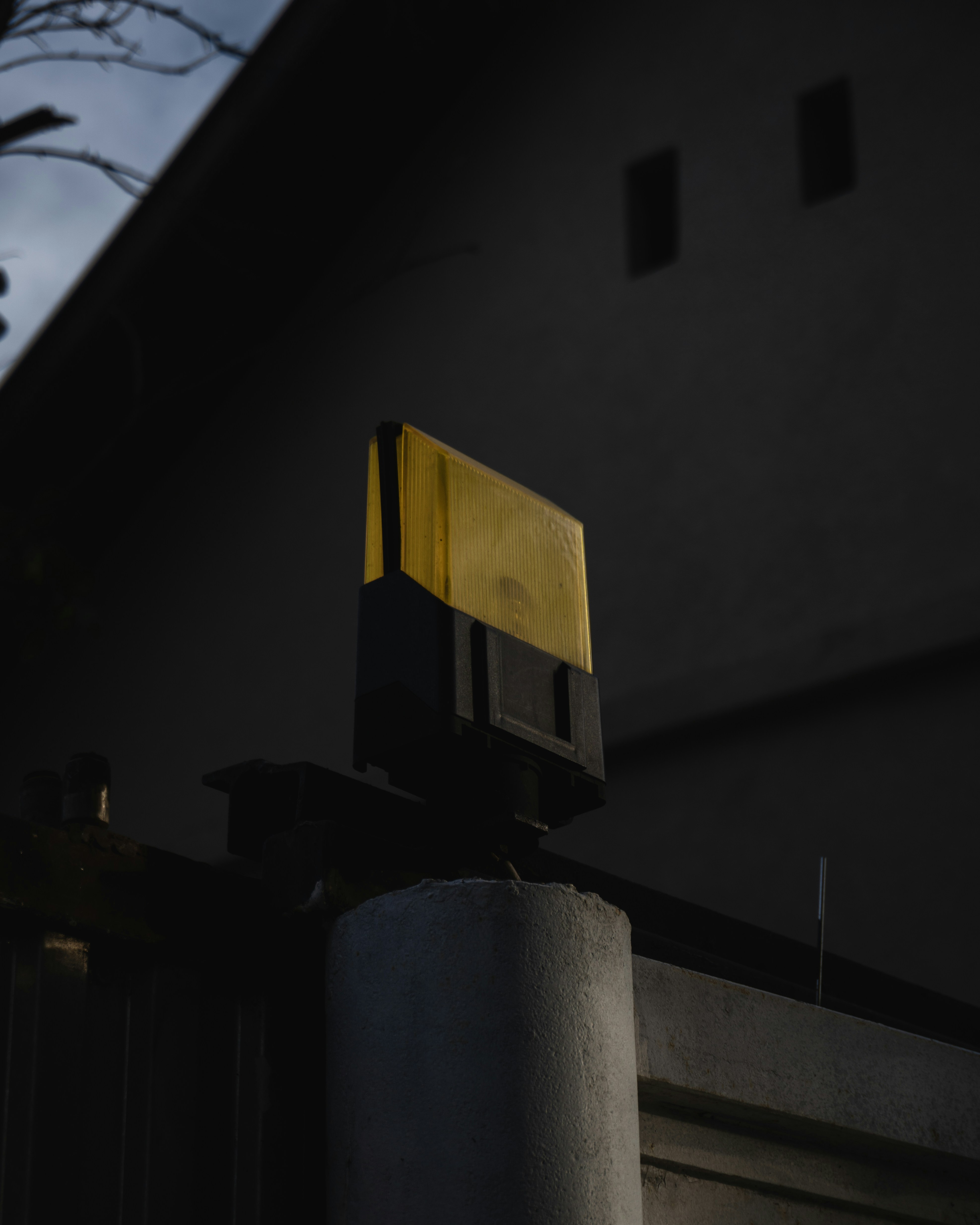 Amber Signal on a Weathered Pillar: A Quiet Industrial Moment