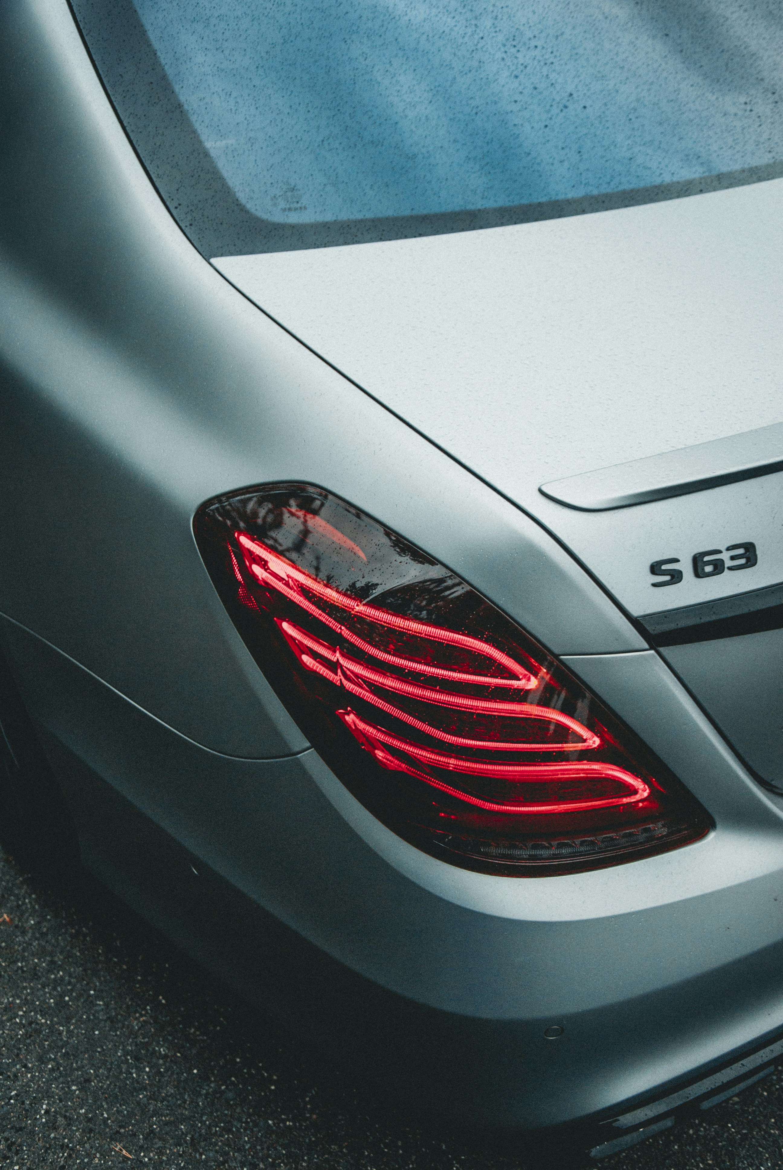 Red Taillight in Silence: Close-Up of a Mercedes-Benz S63's Sculpted Silver Rear