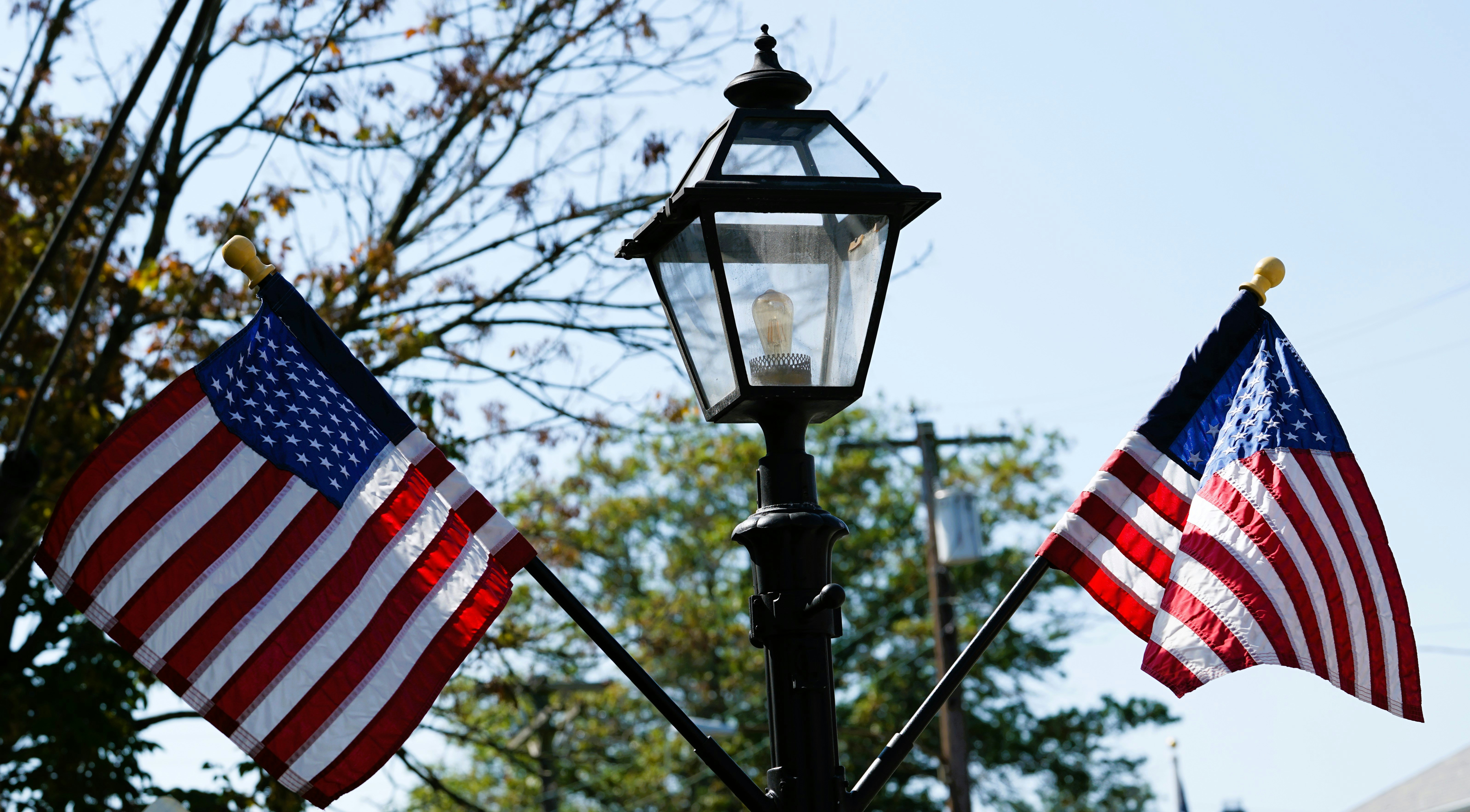 A lamp post with two american flags on it photo – Free Usa Image on ...