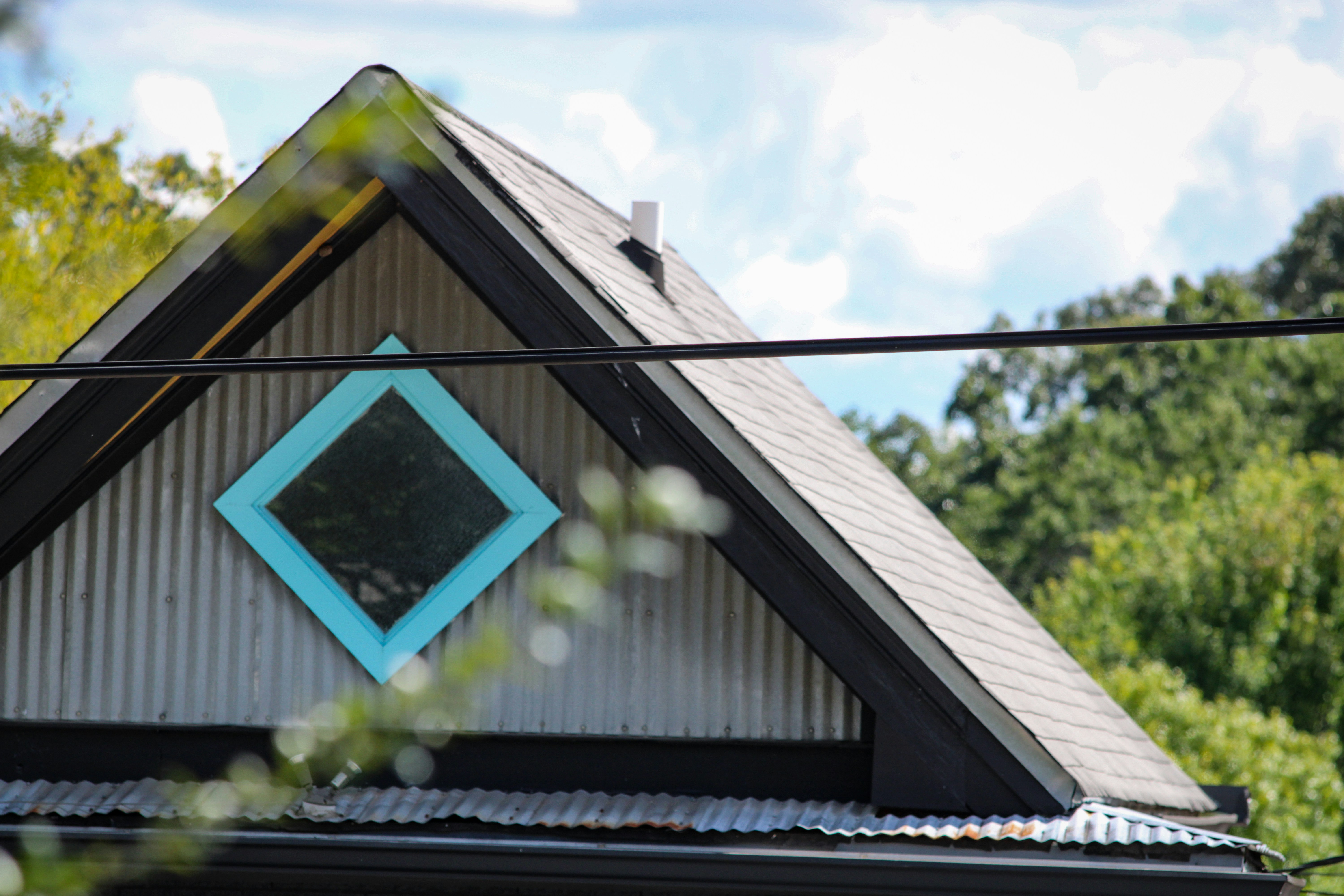 A blue diamond shaped window on the roof of a house photo – Free ...