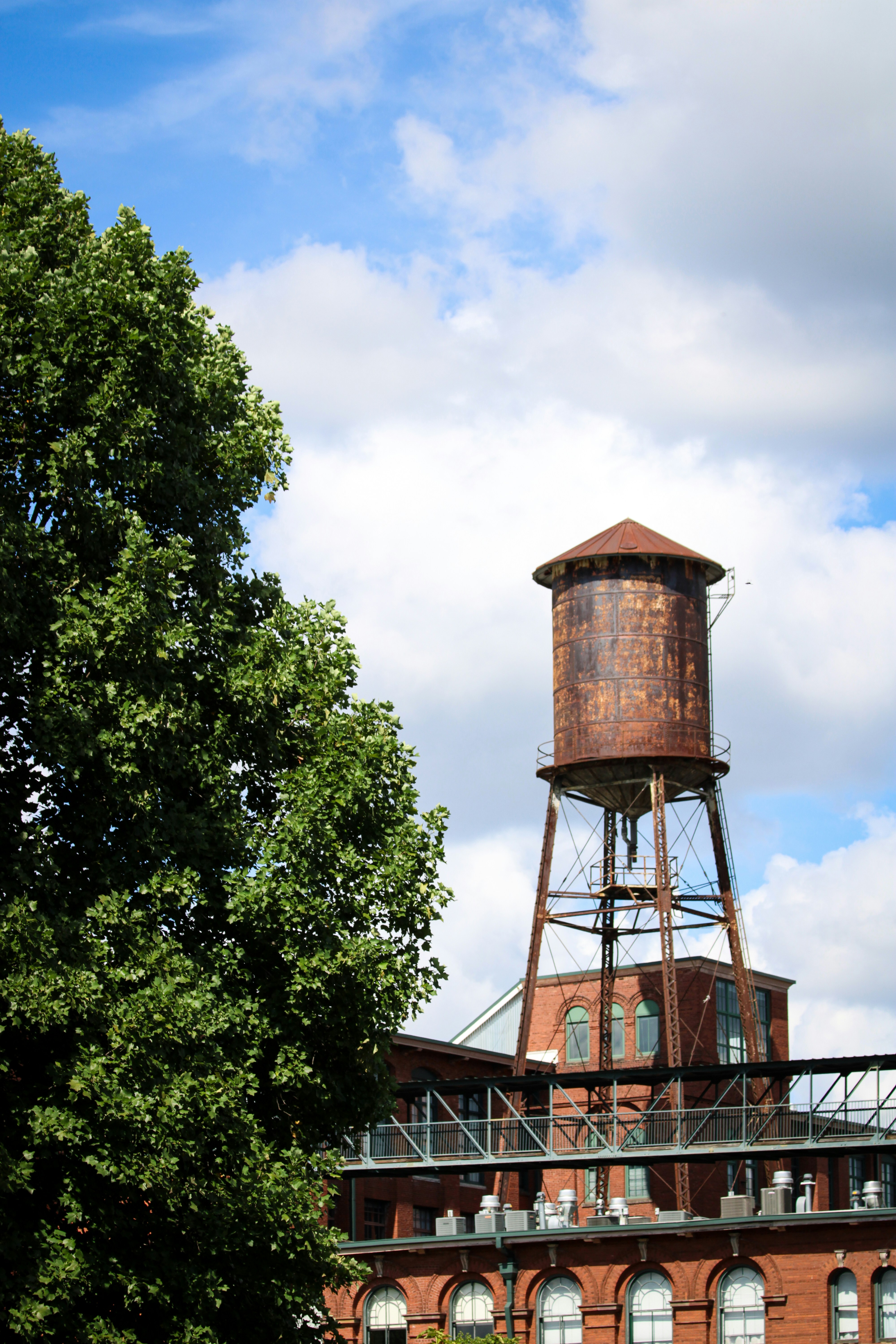 A large brick building with a water tower photo – Free Tower Image on ...