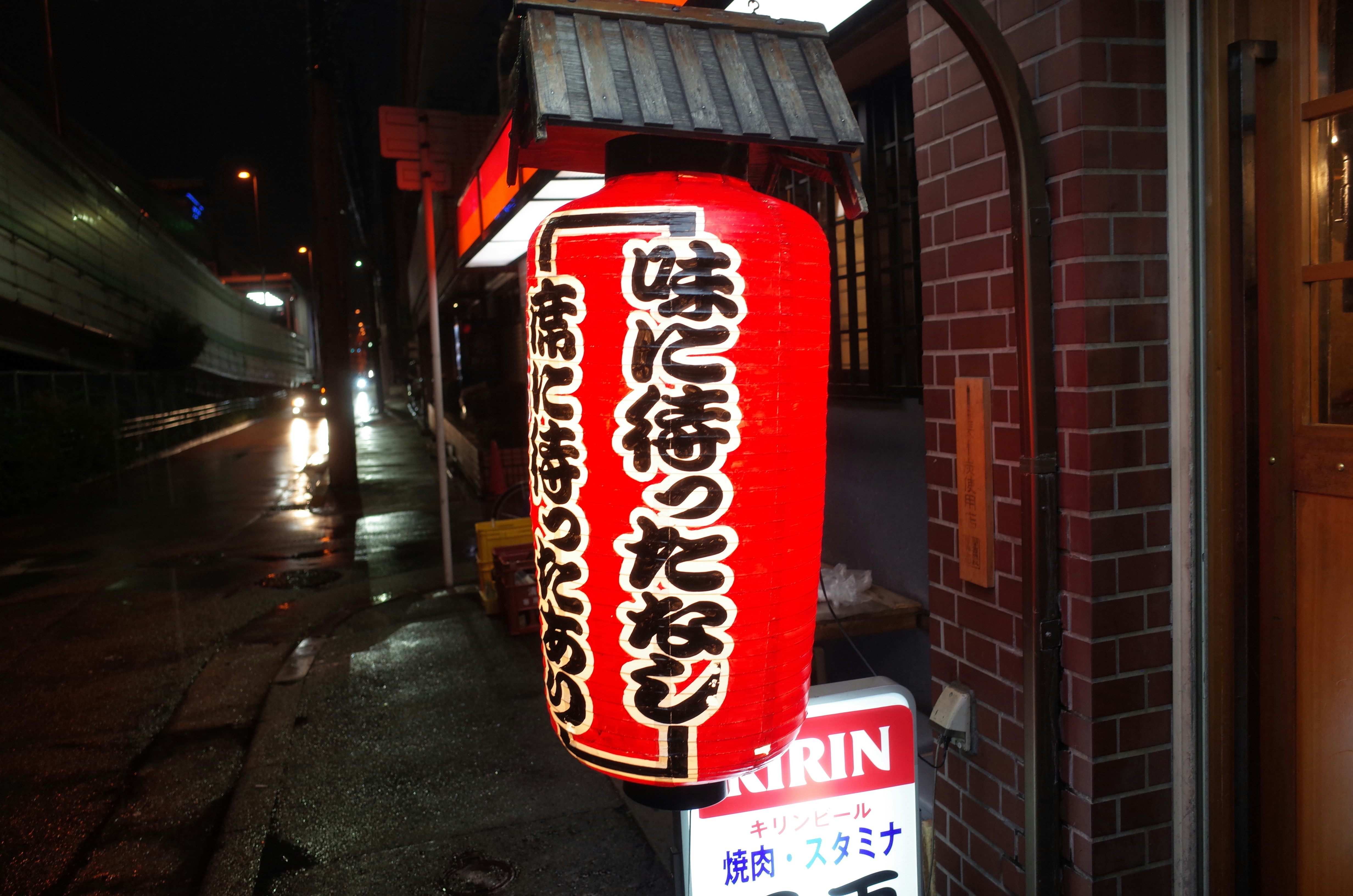 A red lantern with asian writing on the side of a building photo – Free ...