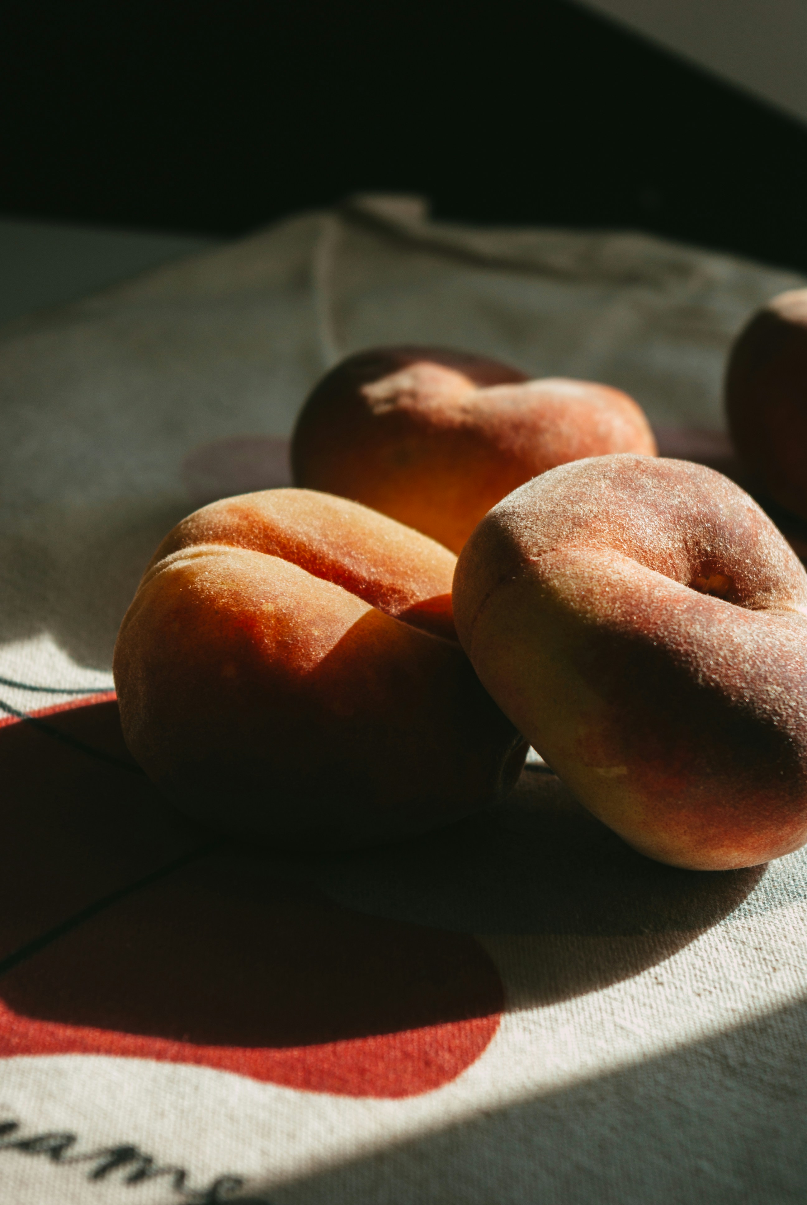 Velvet Peach Still Life in a Shadowed Linen Stage