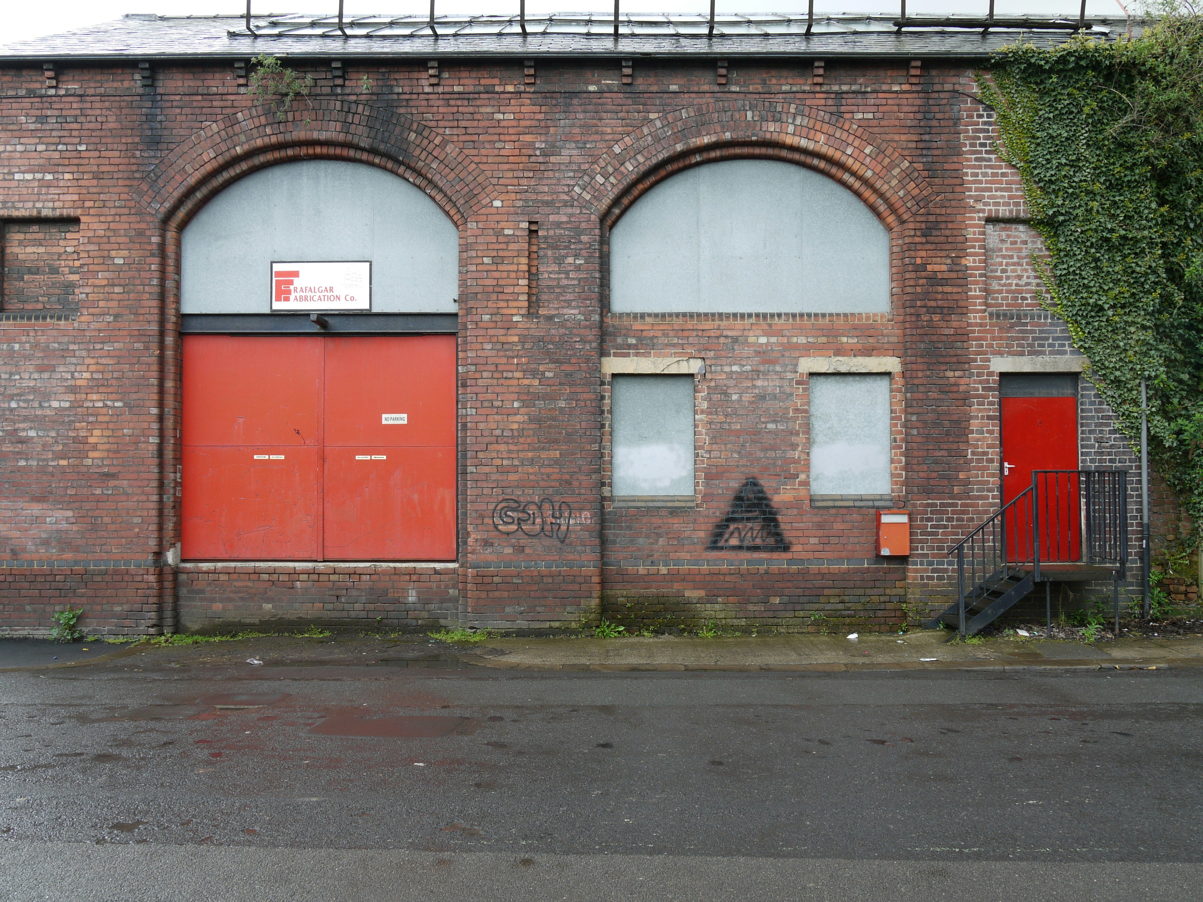 Industrial area in a city | a brick building with two red doors and a red fire hydrant