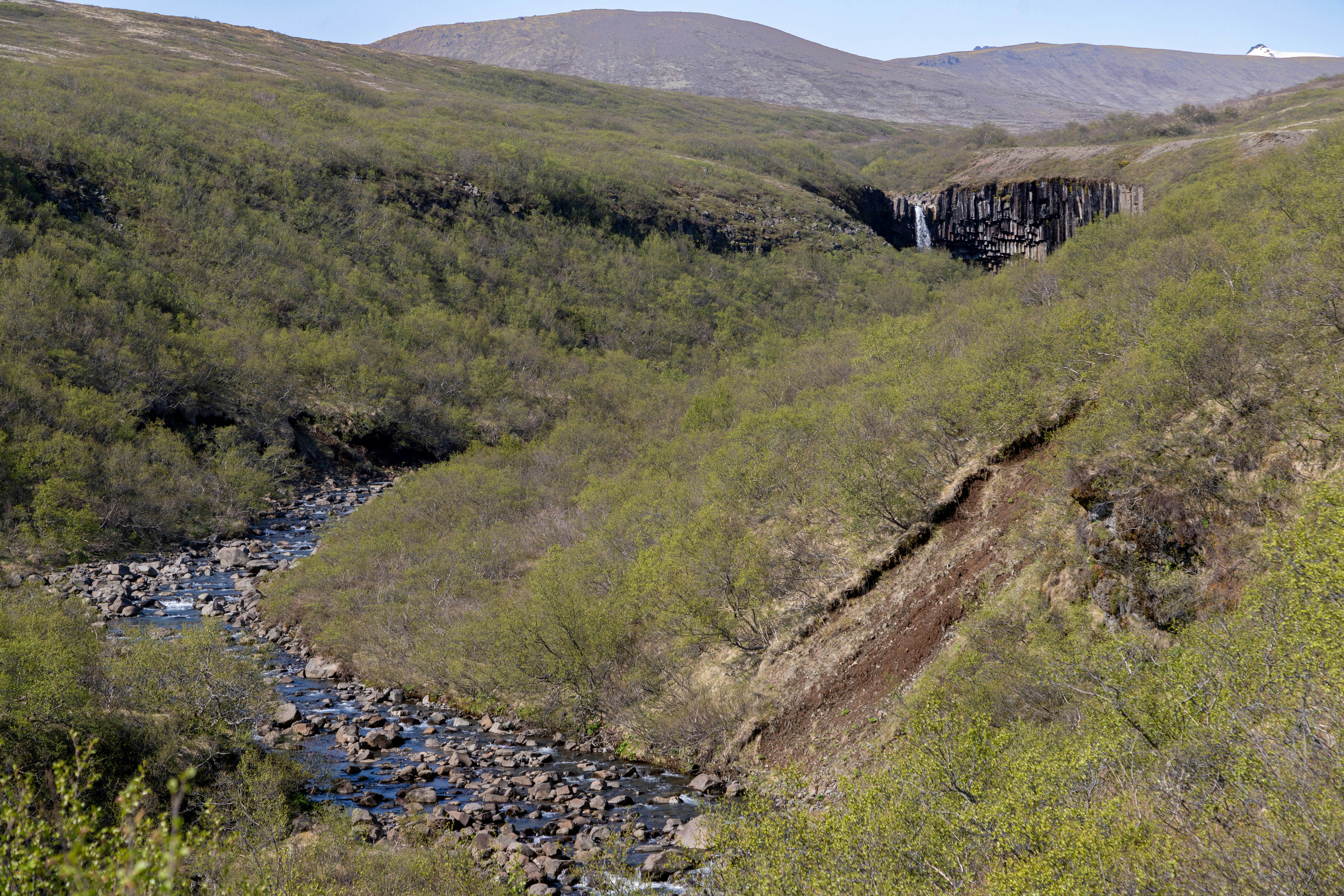 Ridgeline Vista Over a Winding creek and Eroded Slope