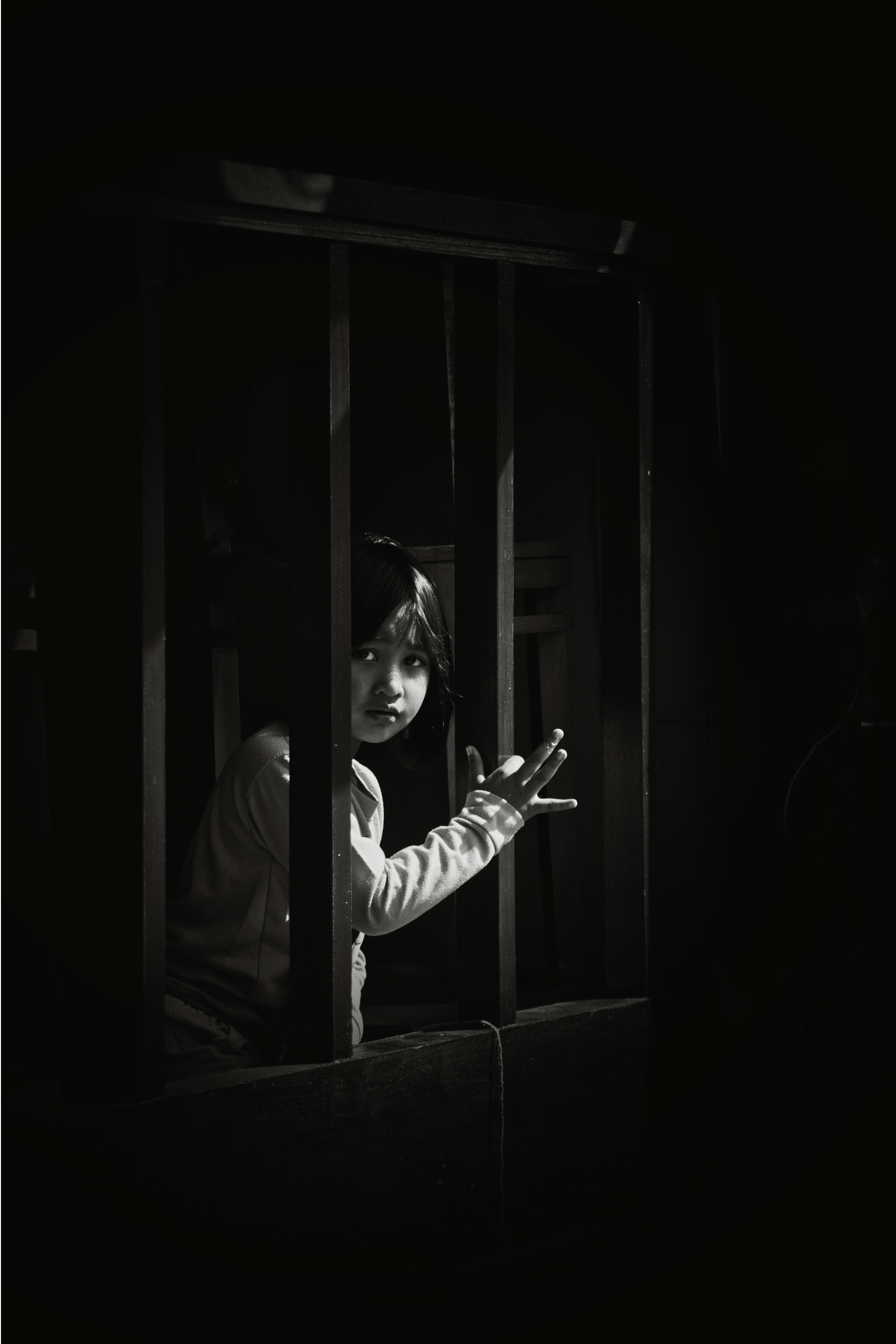 A young girl holding a cell phone in a jail cell photo – Free Bali ...