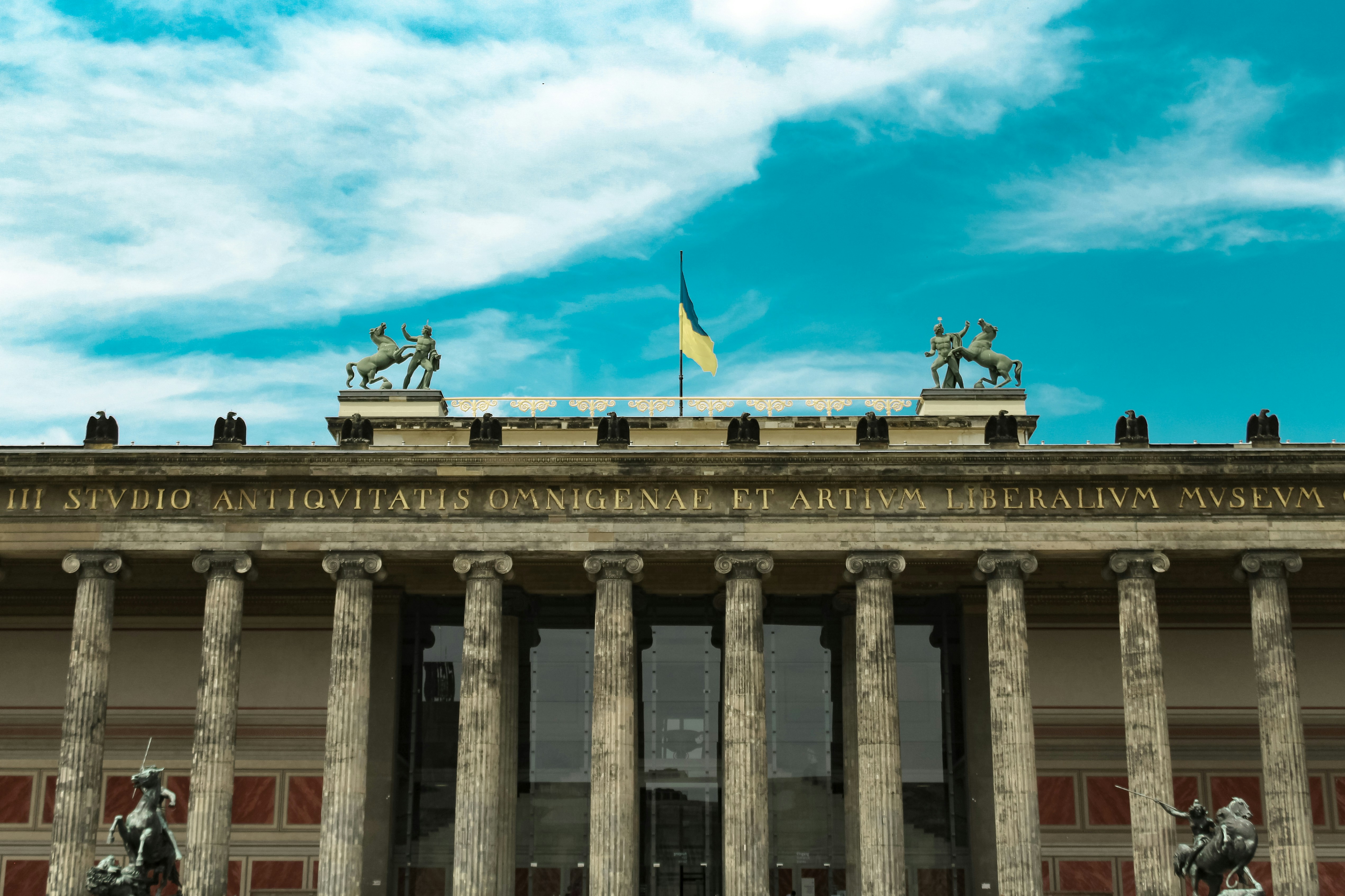 A large building with columns and statues on top of it photo – Free ...