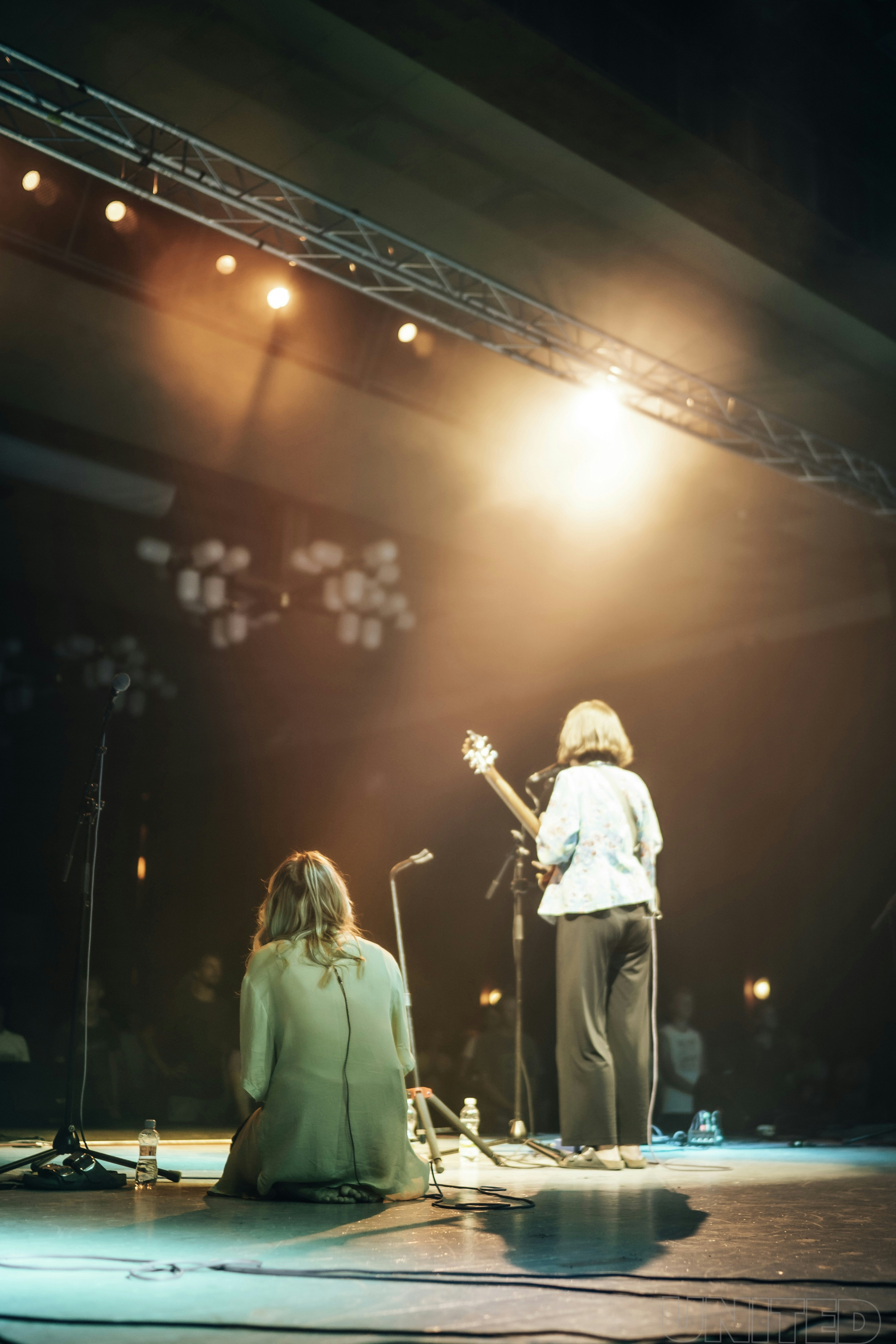 Amber Halo on Stage: A Duo Embraced by Warm Backlight