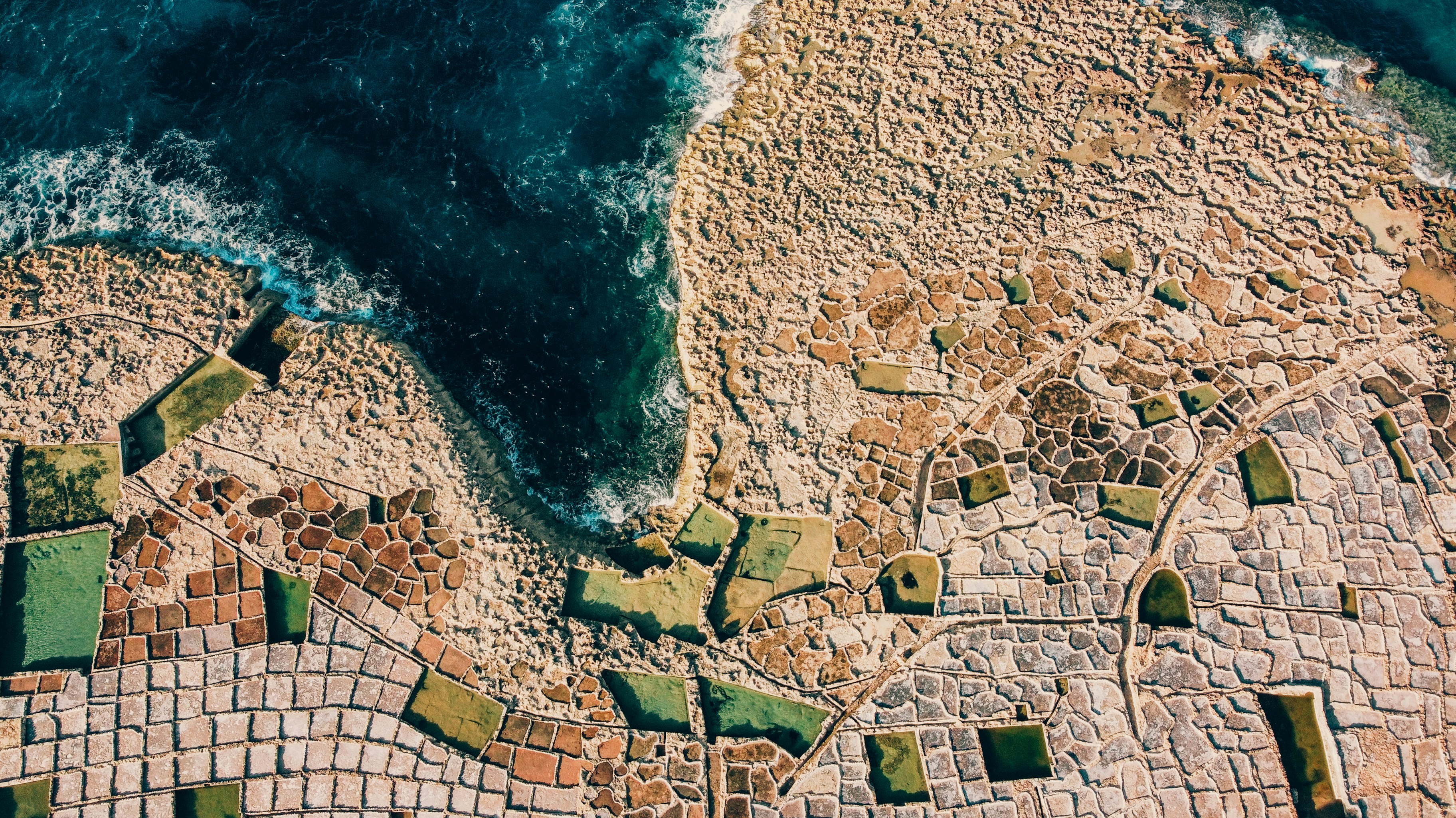 An aerial view of a cobblestone beach and ocean photo – Free Salt pans ...