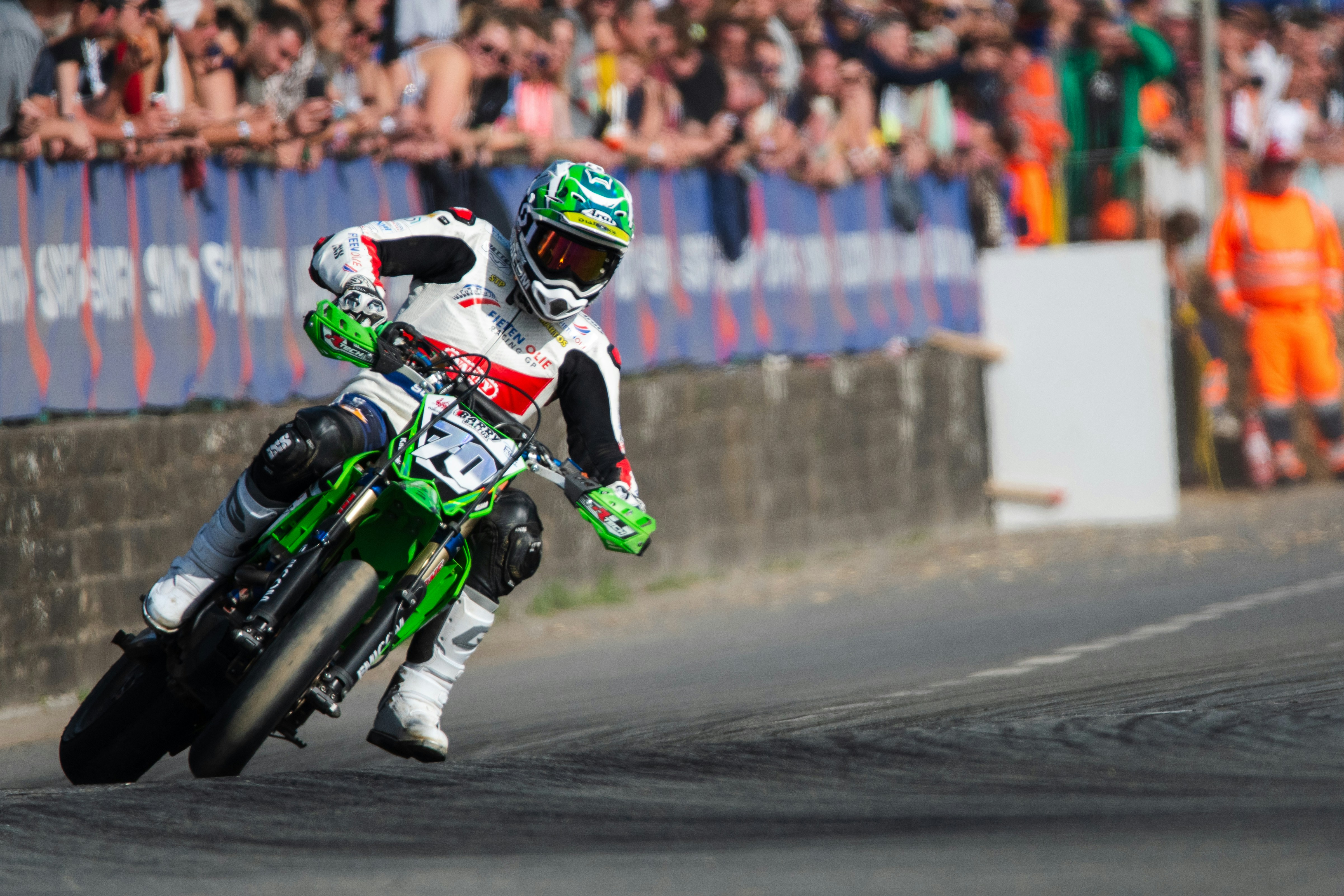 Edge of the Asphalt: Neon-Green Moto Carves a Crowded Street Turn