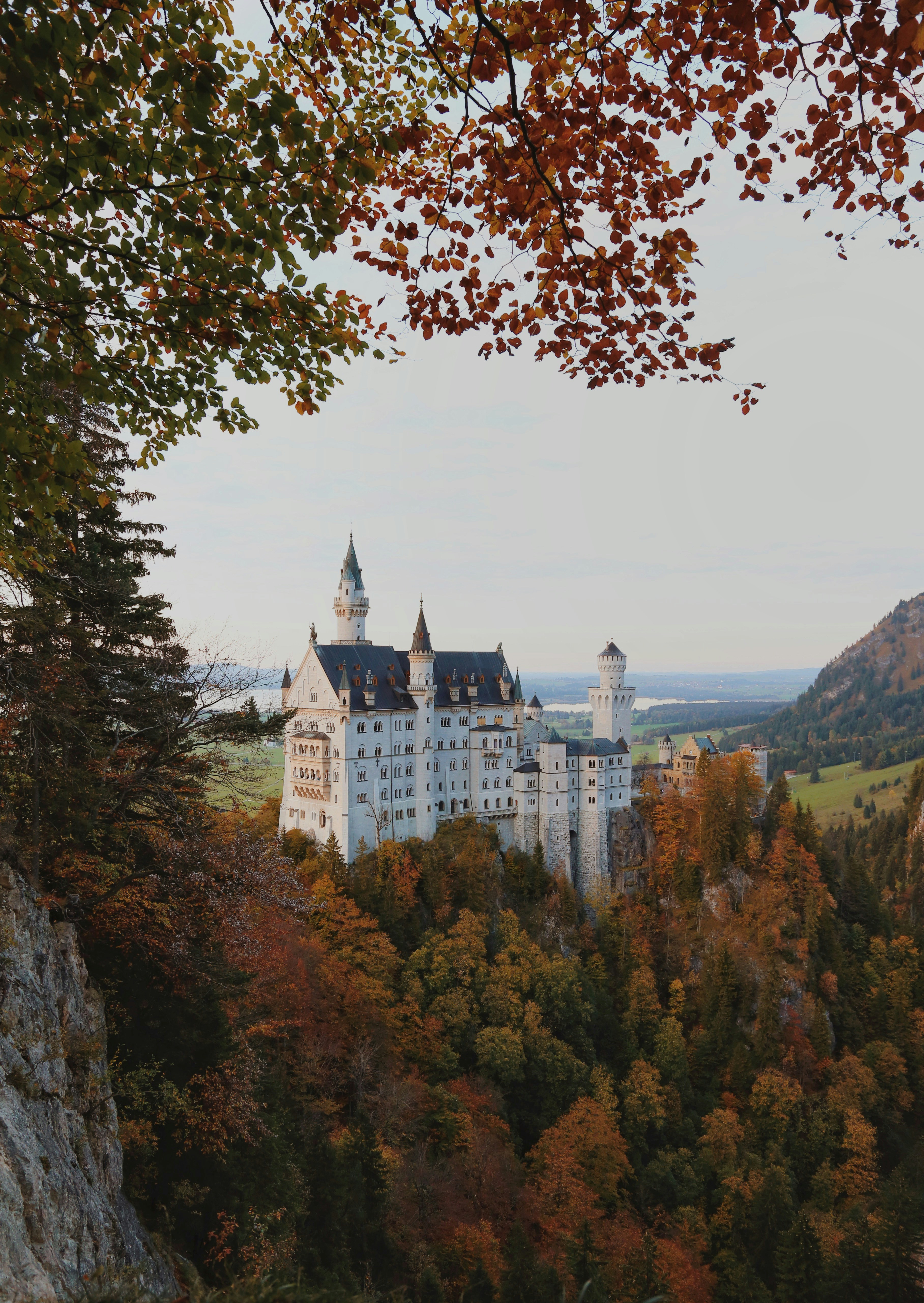 A large white castle sitting on top of a lush green hillside photo ...