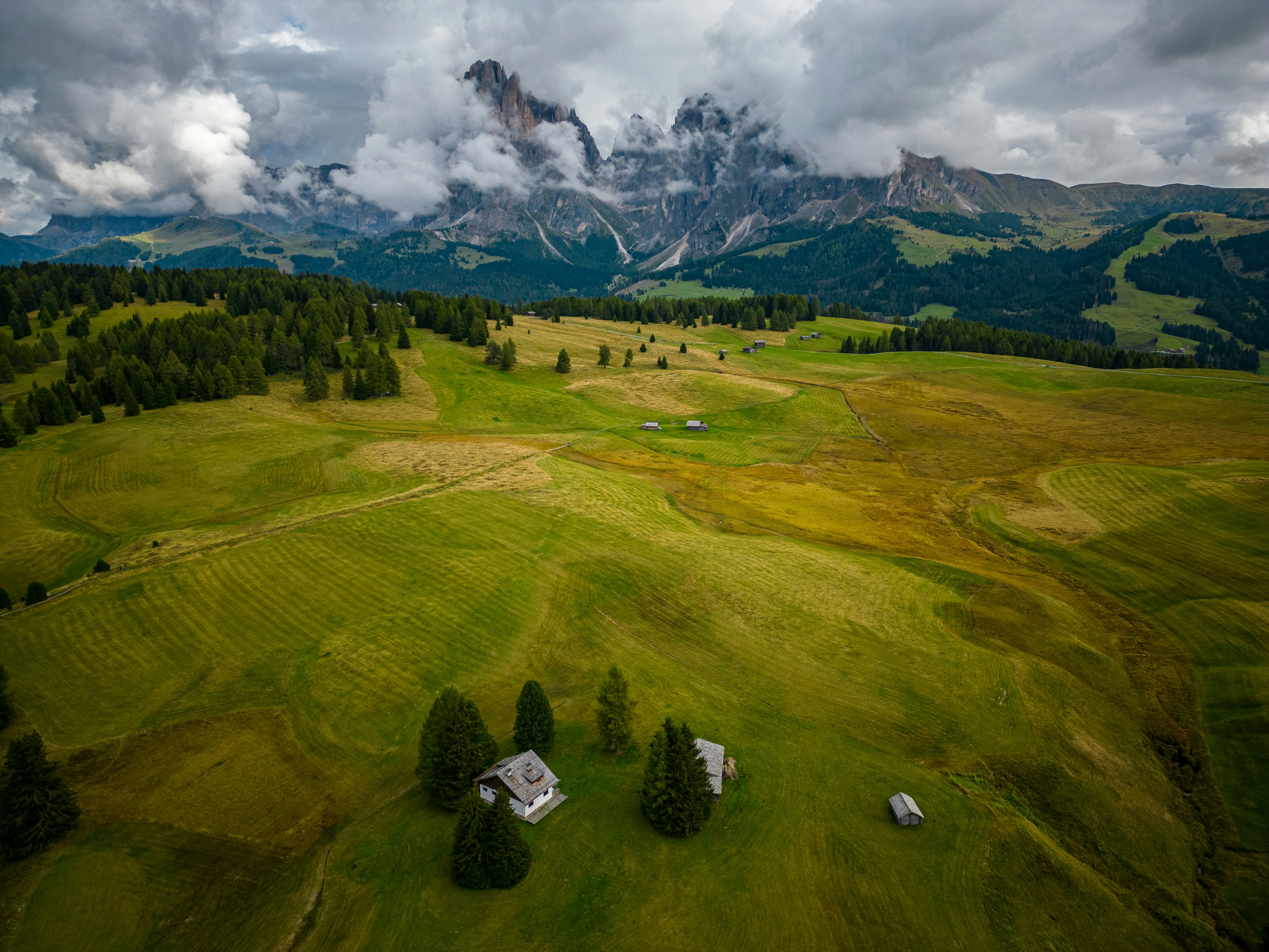 Alpine Pastures Beneath Veiled Peaks: A Drone Portrait of Quiet Farmstead Clusters