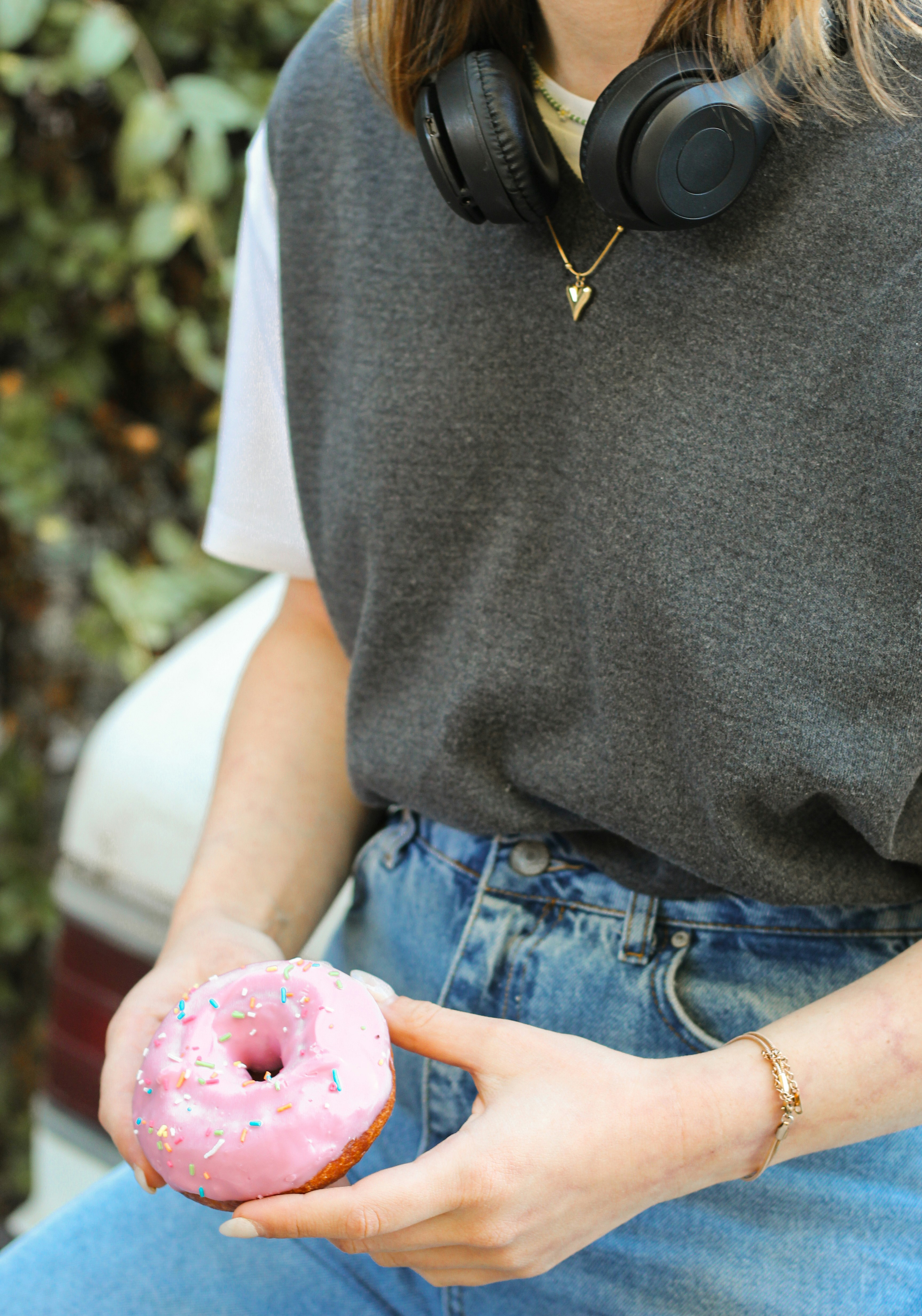 a woman wearing headphones holding a doughnut