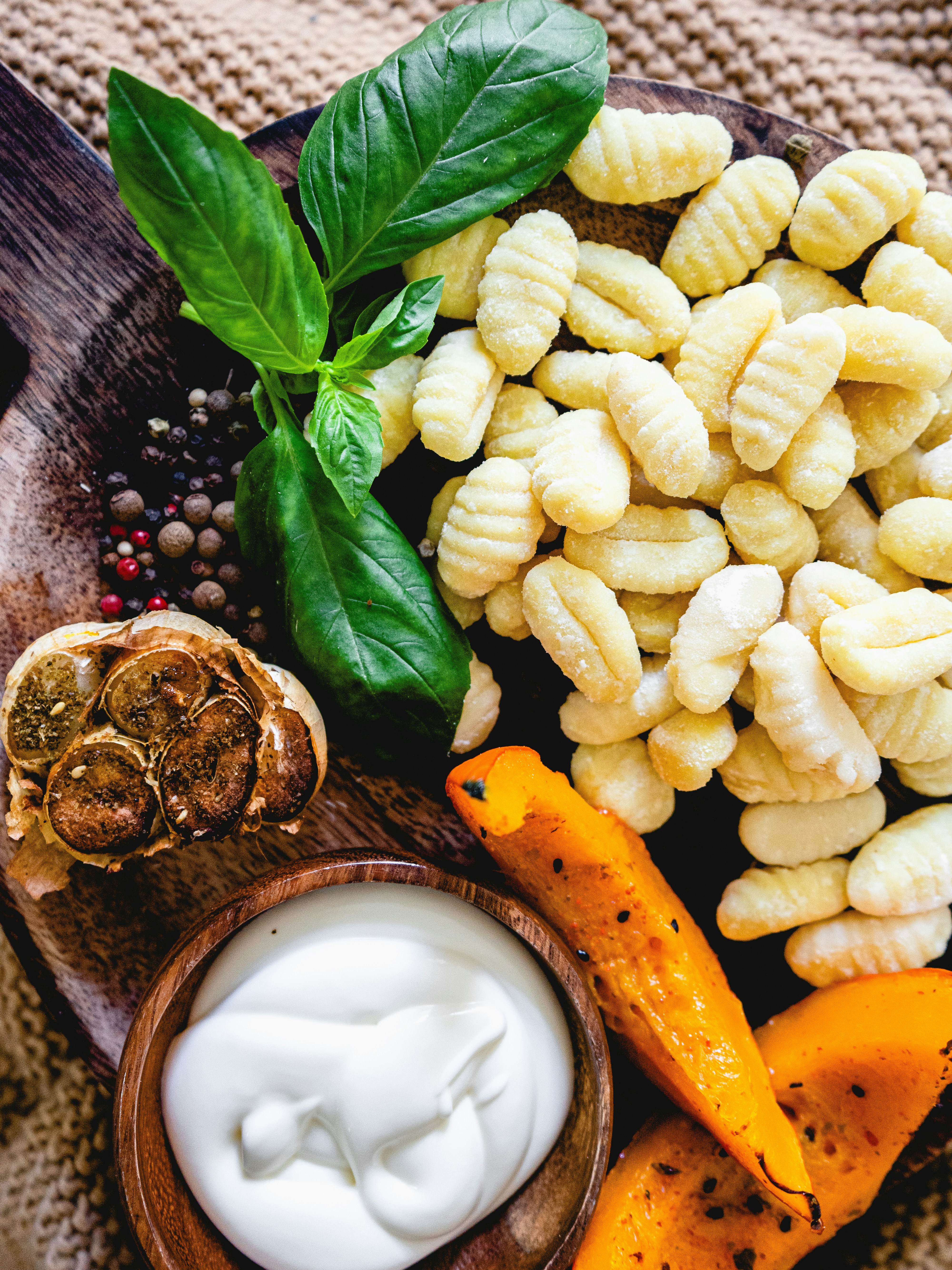 Golden Gnocchi Mosaic: Basil, Roasted Garlic, and Cream on Wood