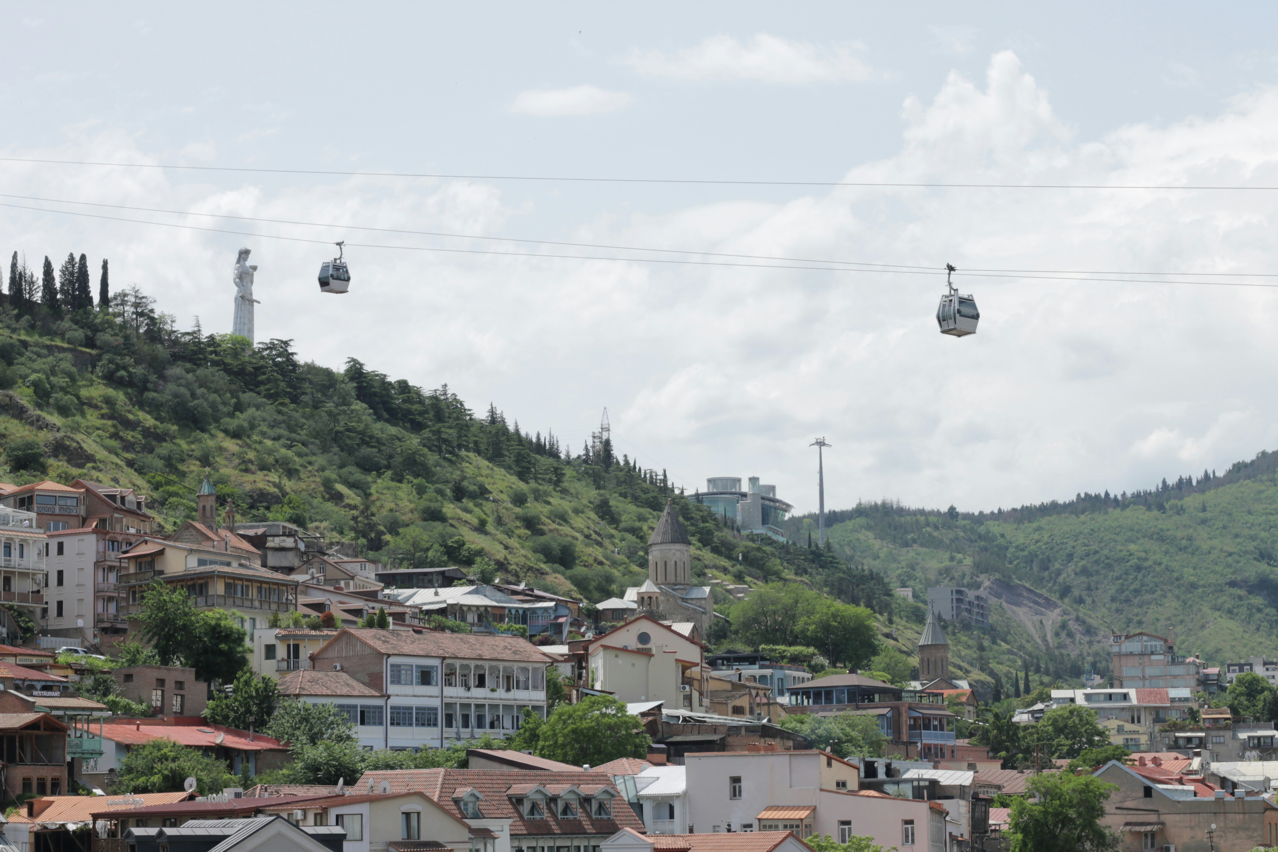 A cable car going over a city with a mountain in the background photo ...