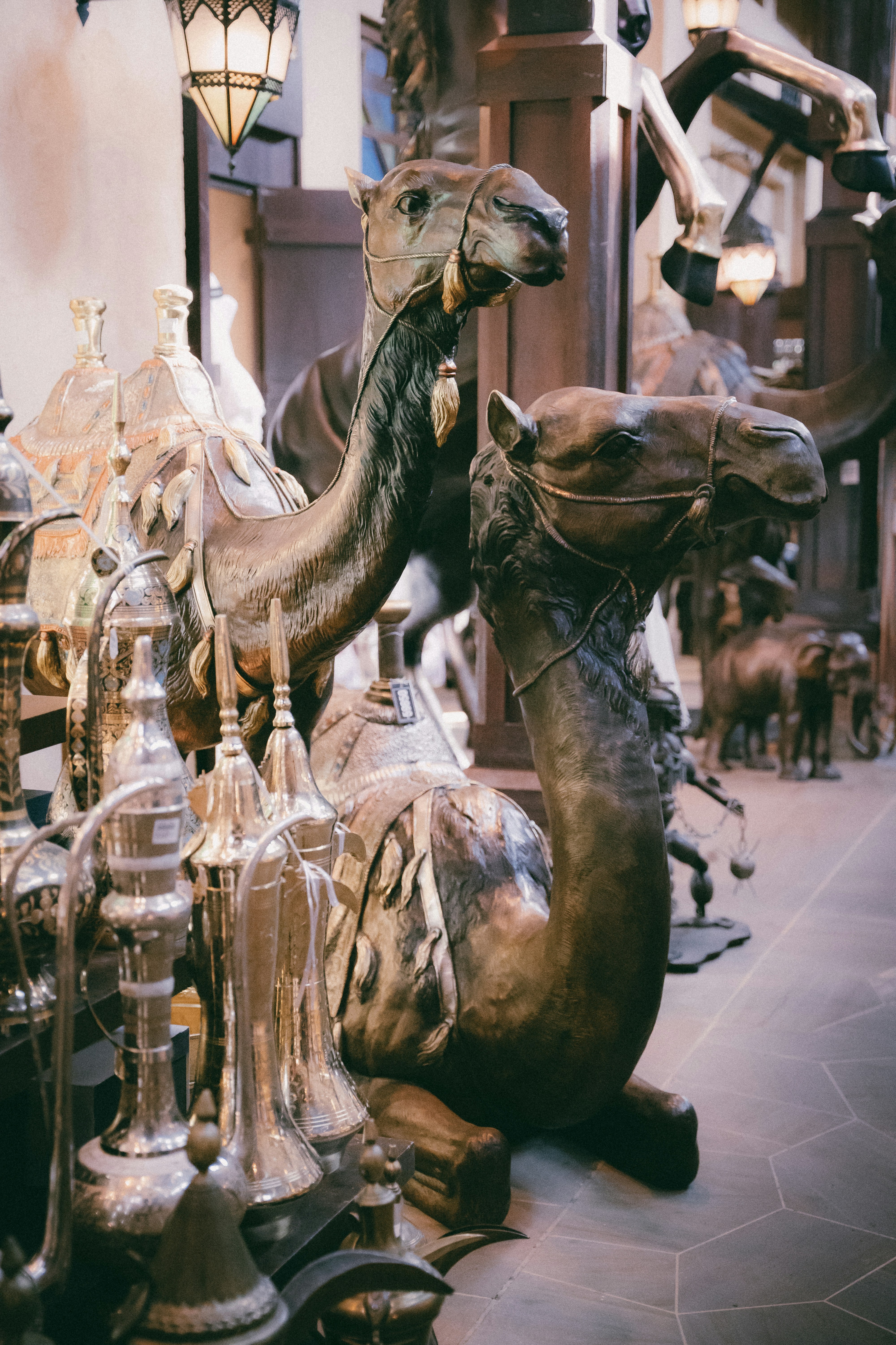A group of camel statues sitting on top of a tiled floor photo – Free ...