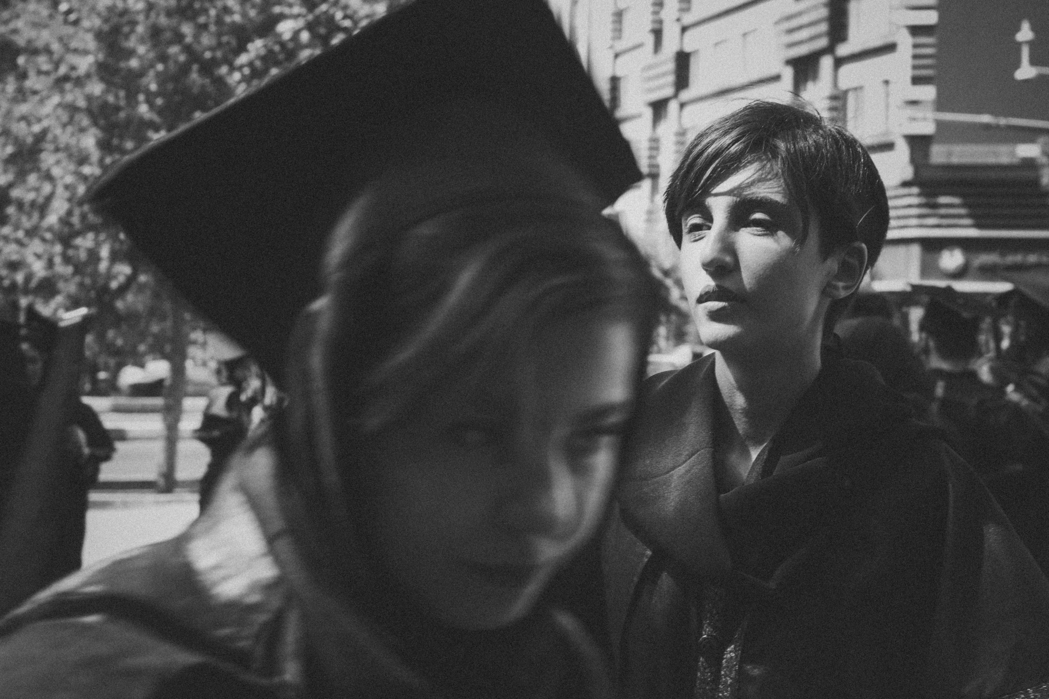 Under the Graduation Cap, City Light: A Quiet Moment Between Faces