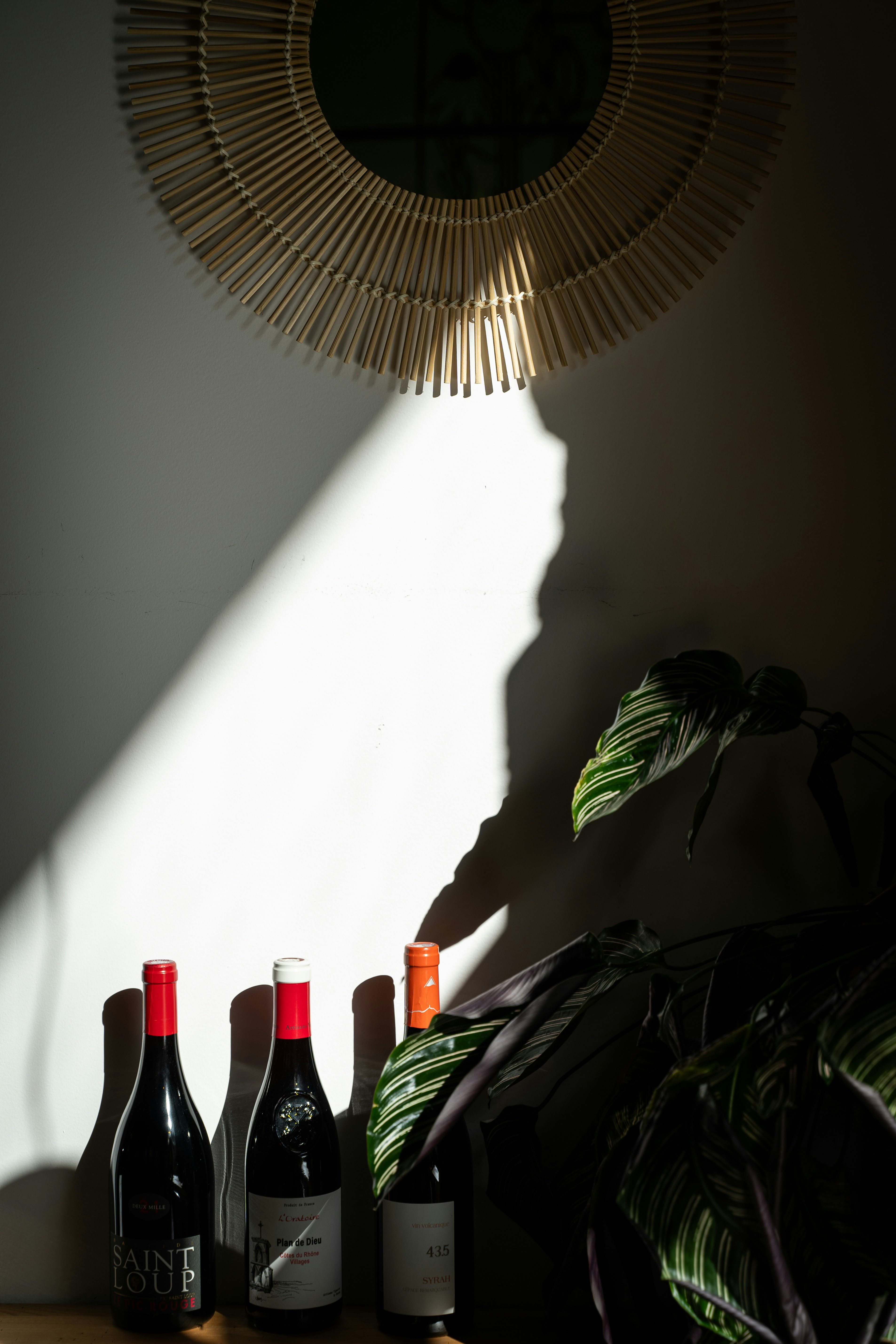 Sunburst Mirror Over a Wine Nook Bathed in a Diagonal Light
