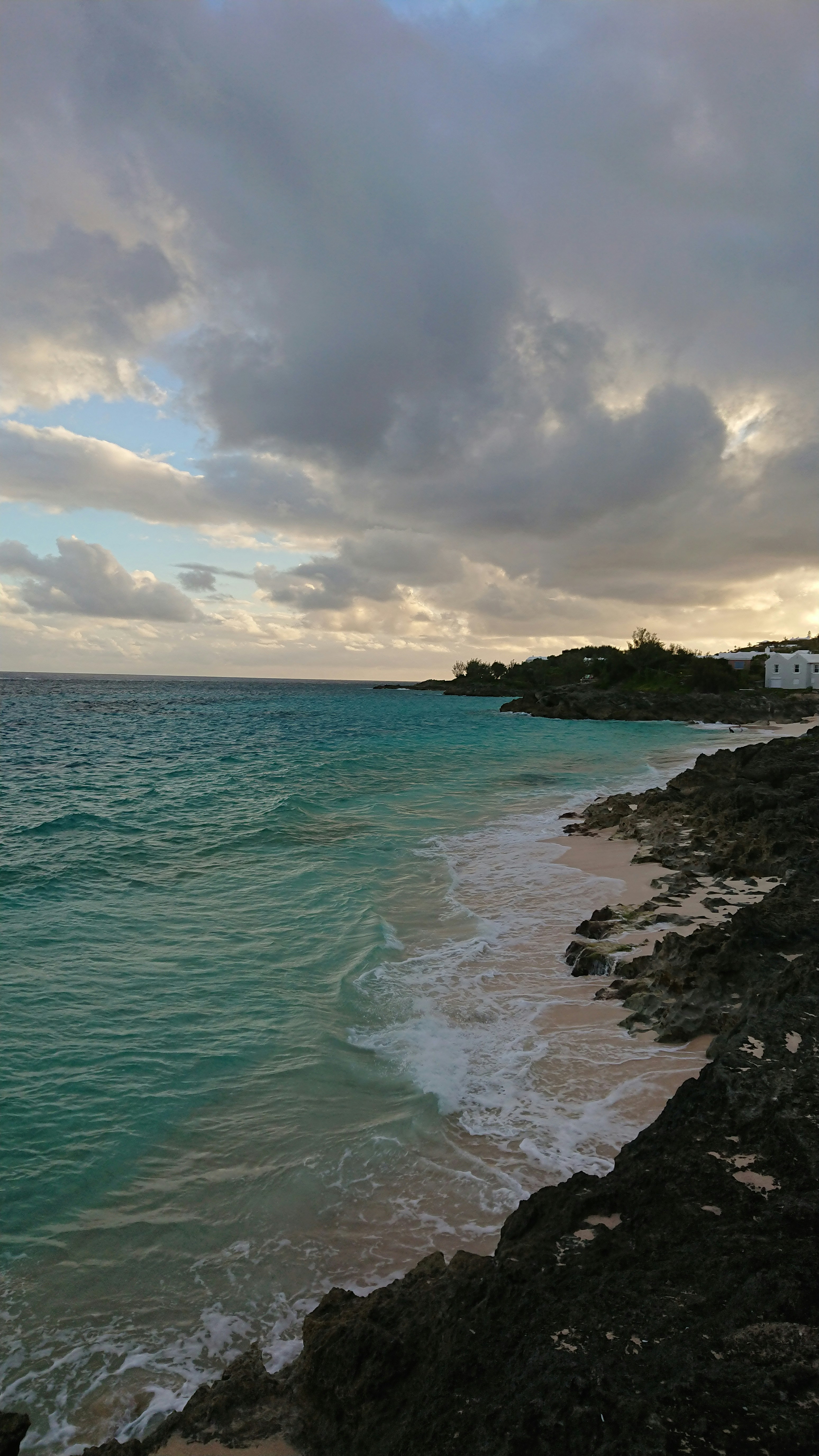 Coastal Edge: Turquoise Waters Meet Volcanic Rocks at Dusk