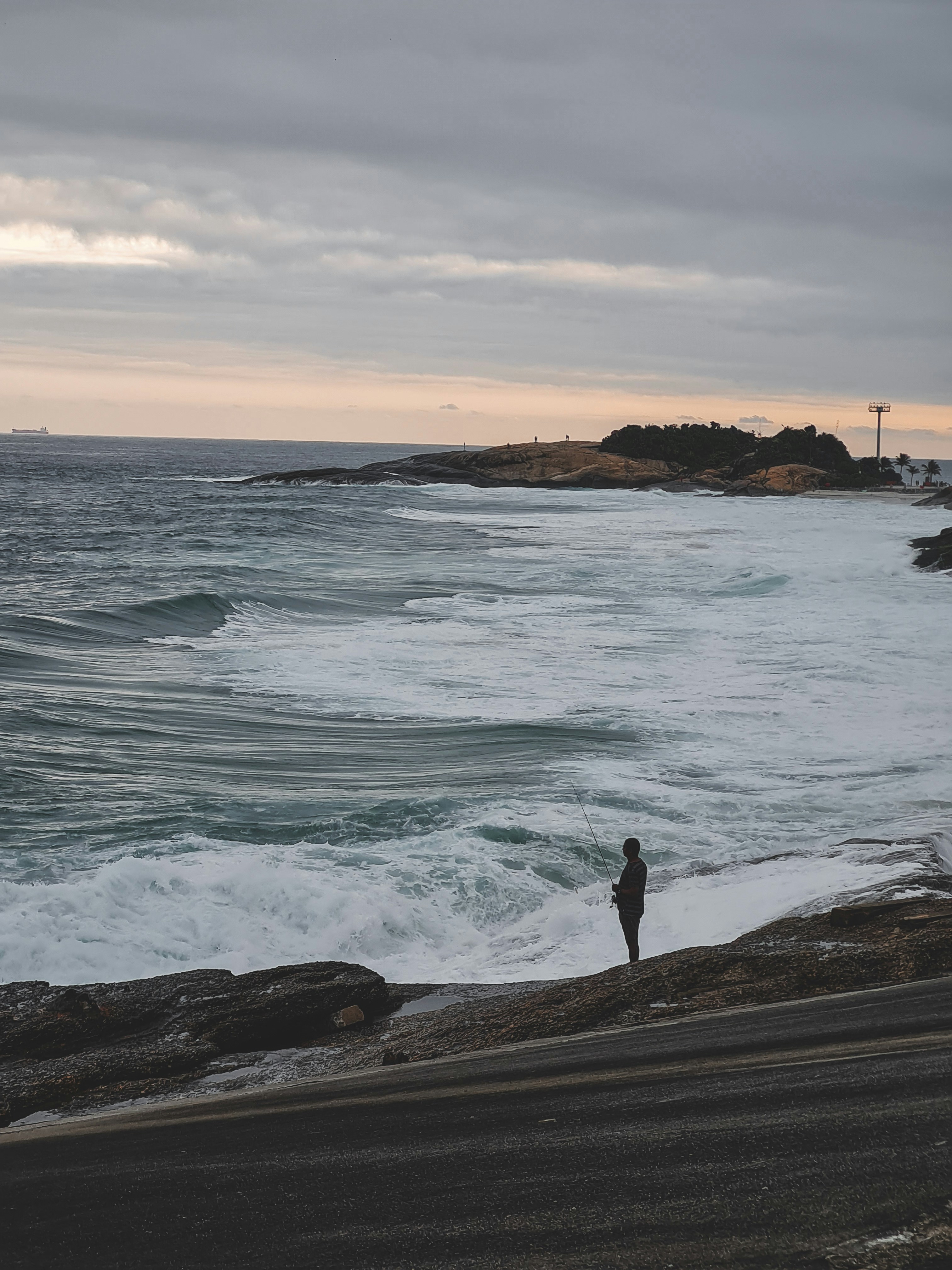  lone figure at the edge of the sea watching the breakers