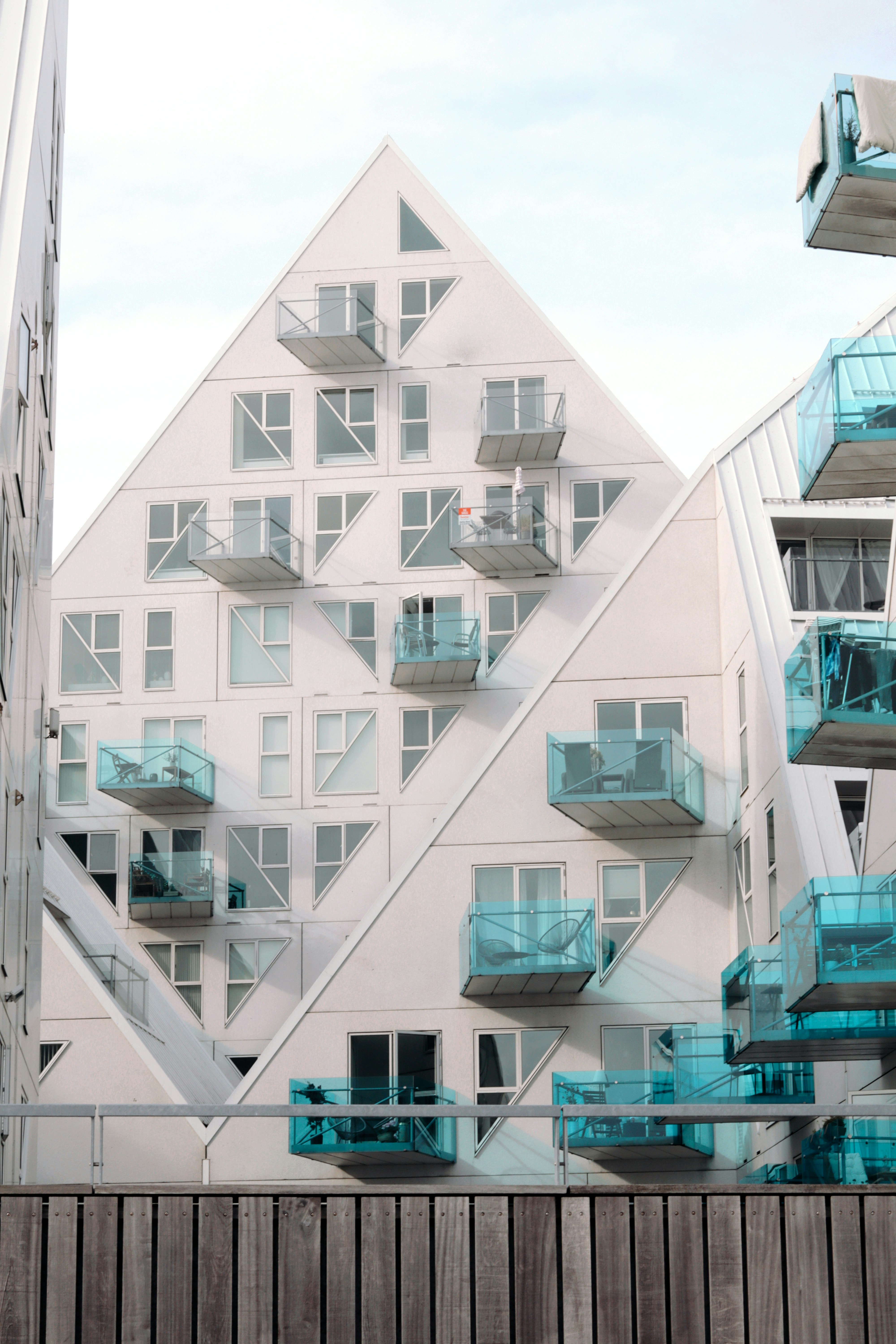 Diamond Prism: White Triangular Building with Cyan Glass Balconies