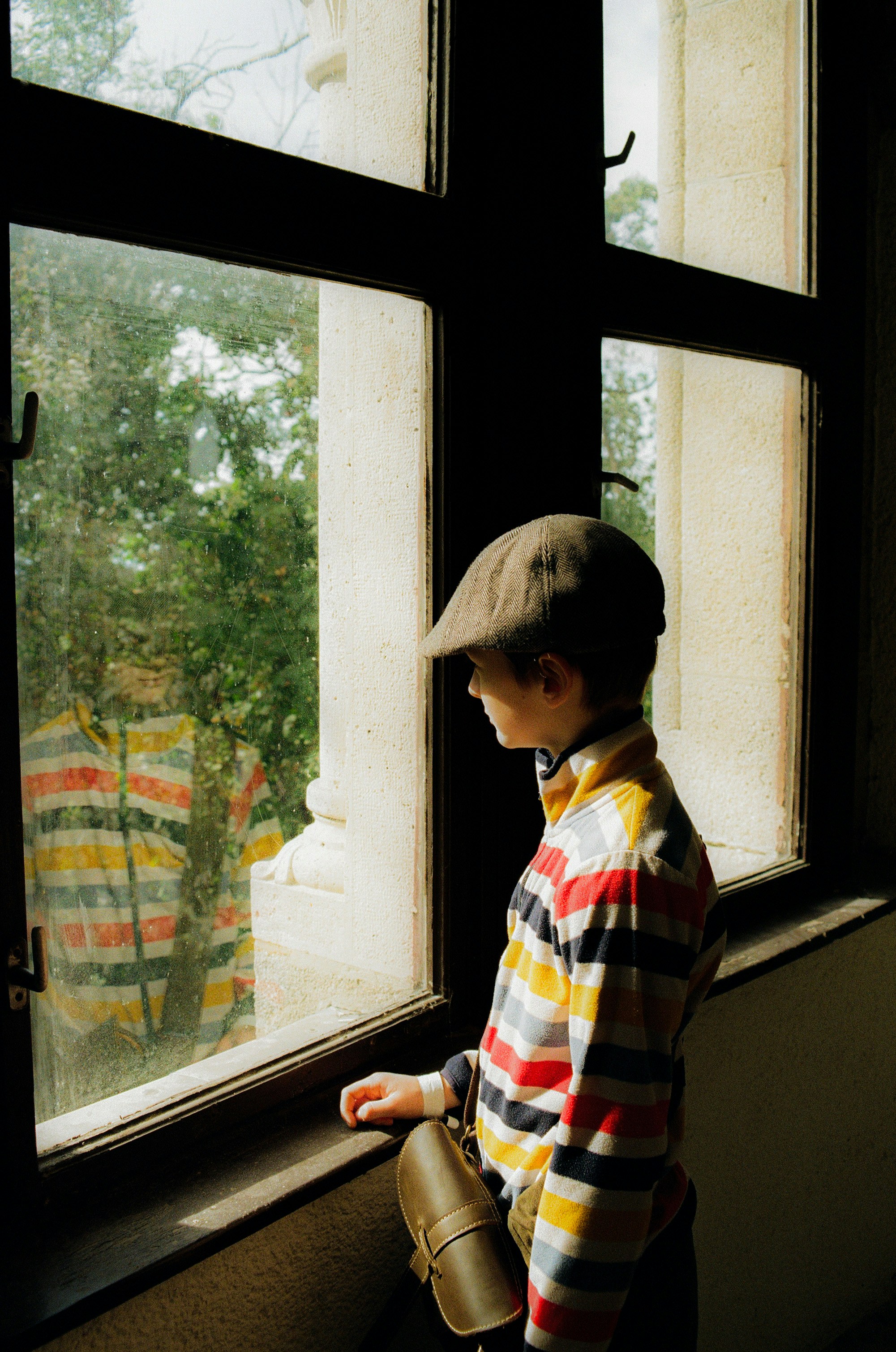 A young boy standing in front of a window photo – Free Analogue ...