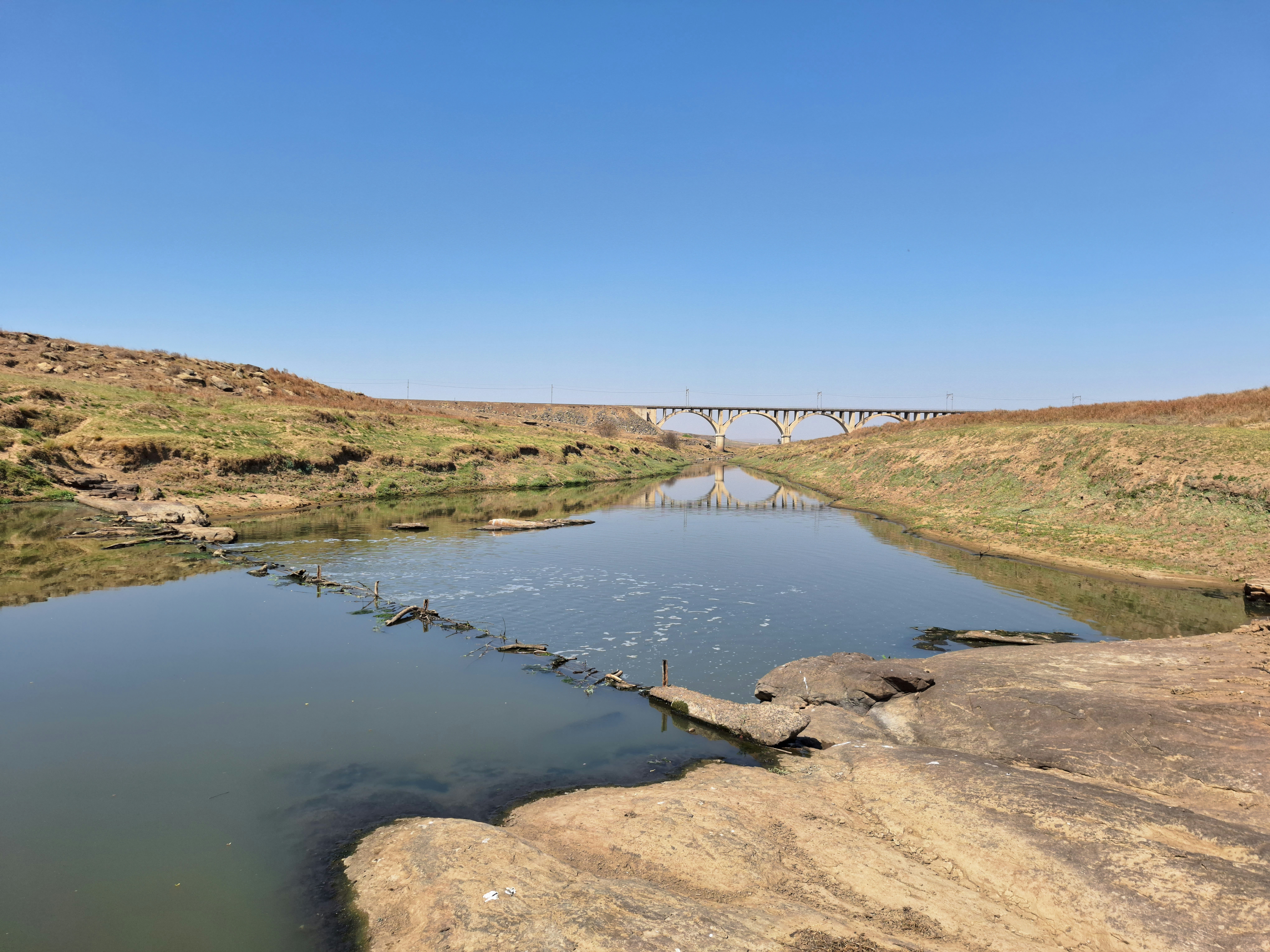 Arched Bridge over a Quiet River: Echoes of Stone and Sky