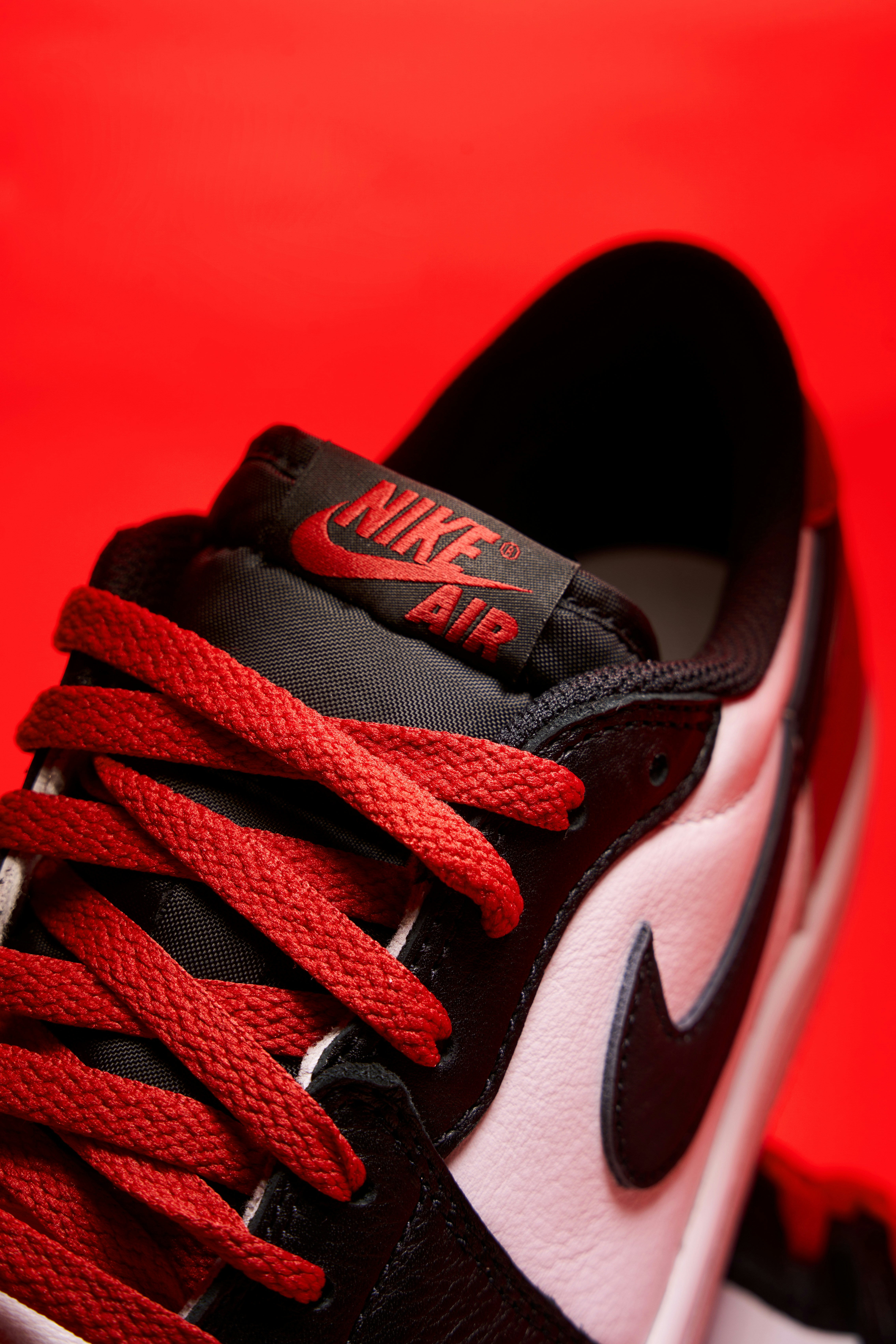 A pair of black and red sneakers on a red background photo – Free Red ...